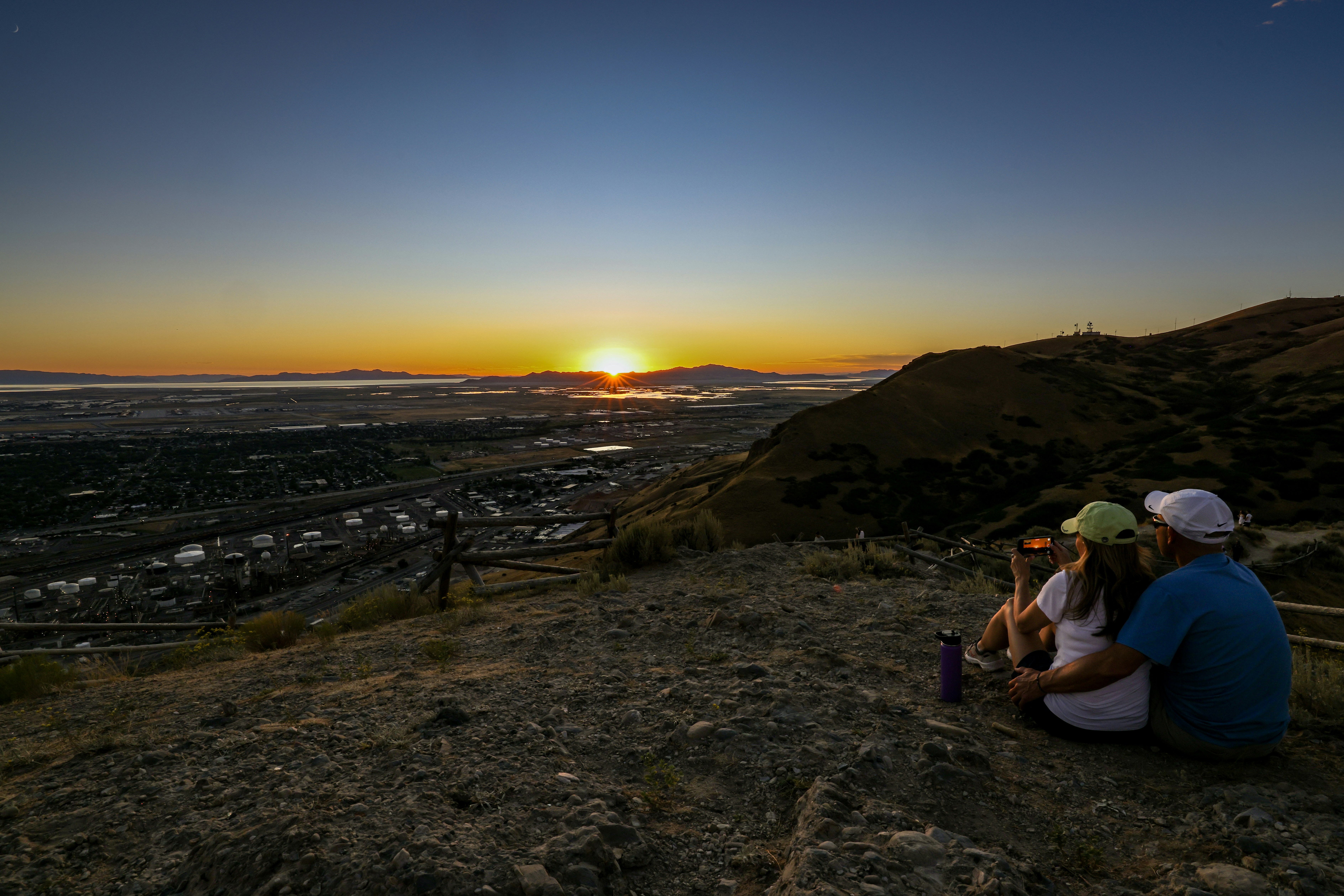 The hiker reward. | Couple watches the sunset over the city.