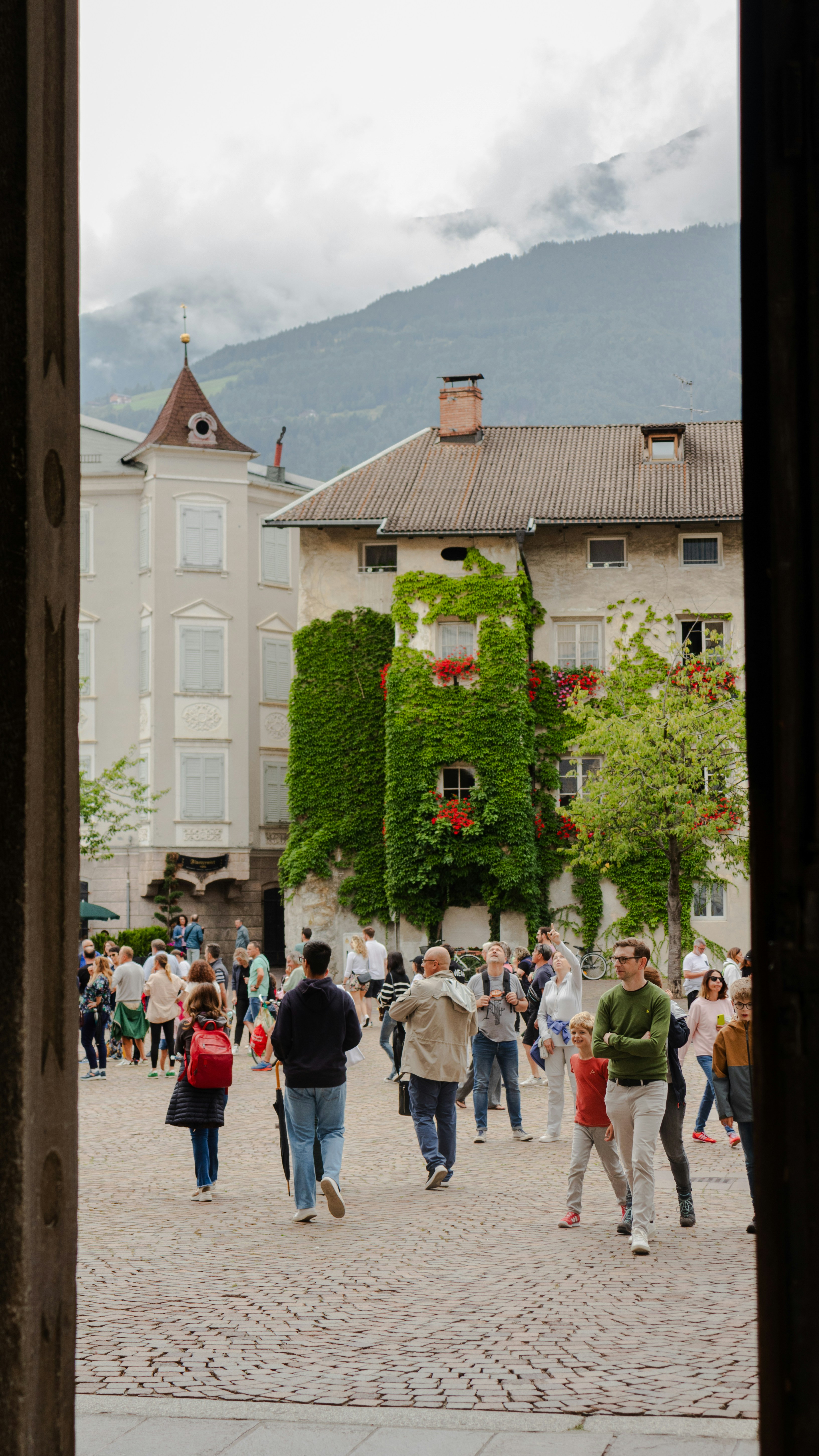 People walk through a european town square.