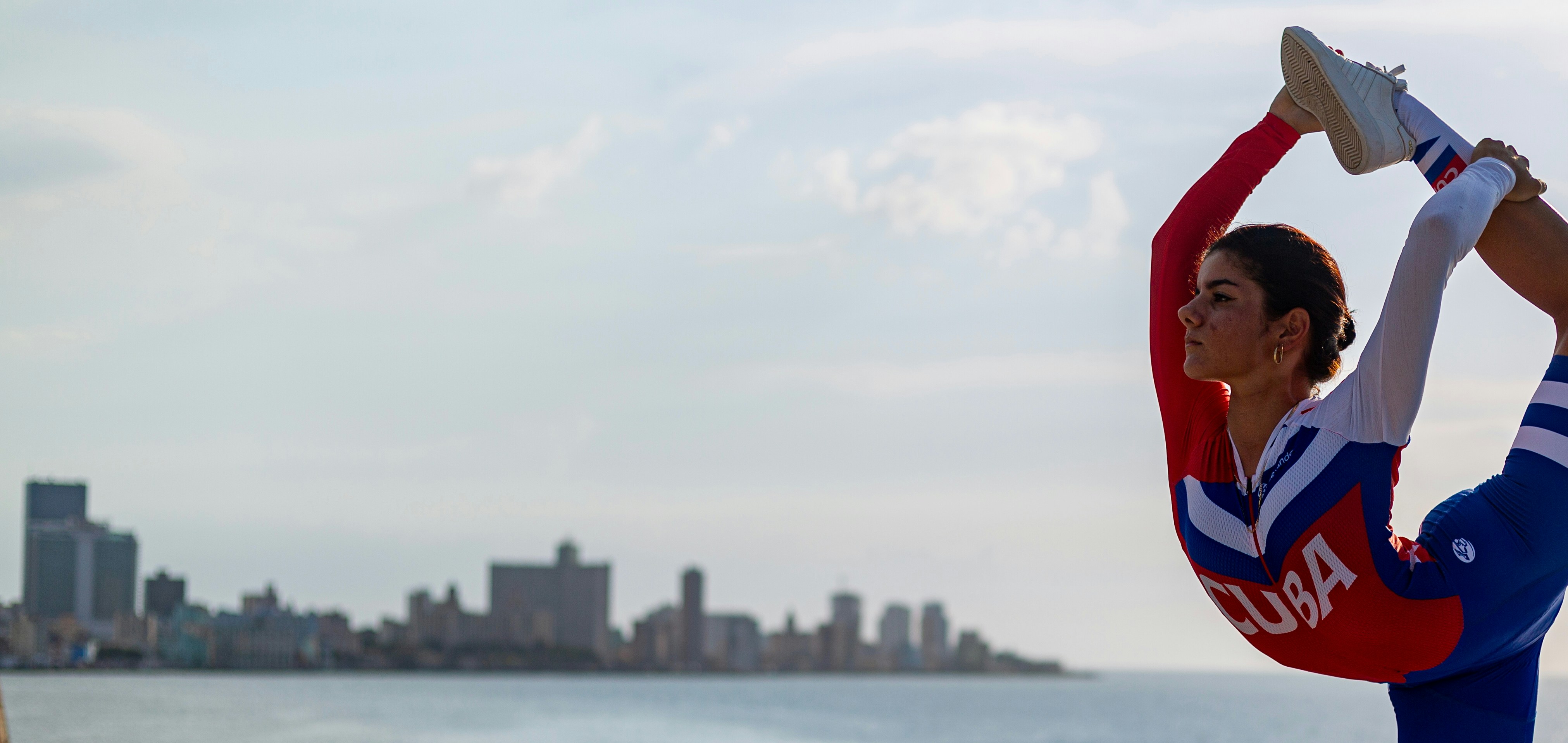 Havana cycling | A gymnast is stretching with a beautiful cityscape backdrop.