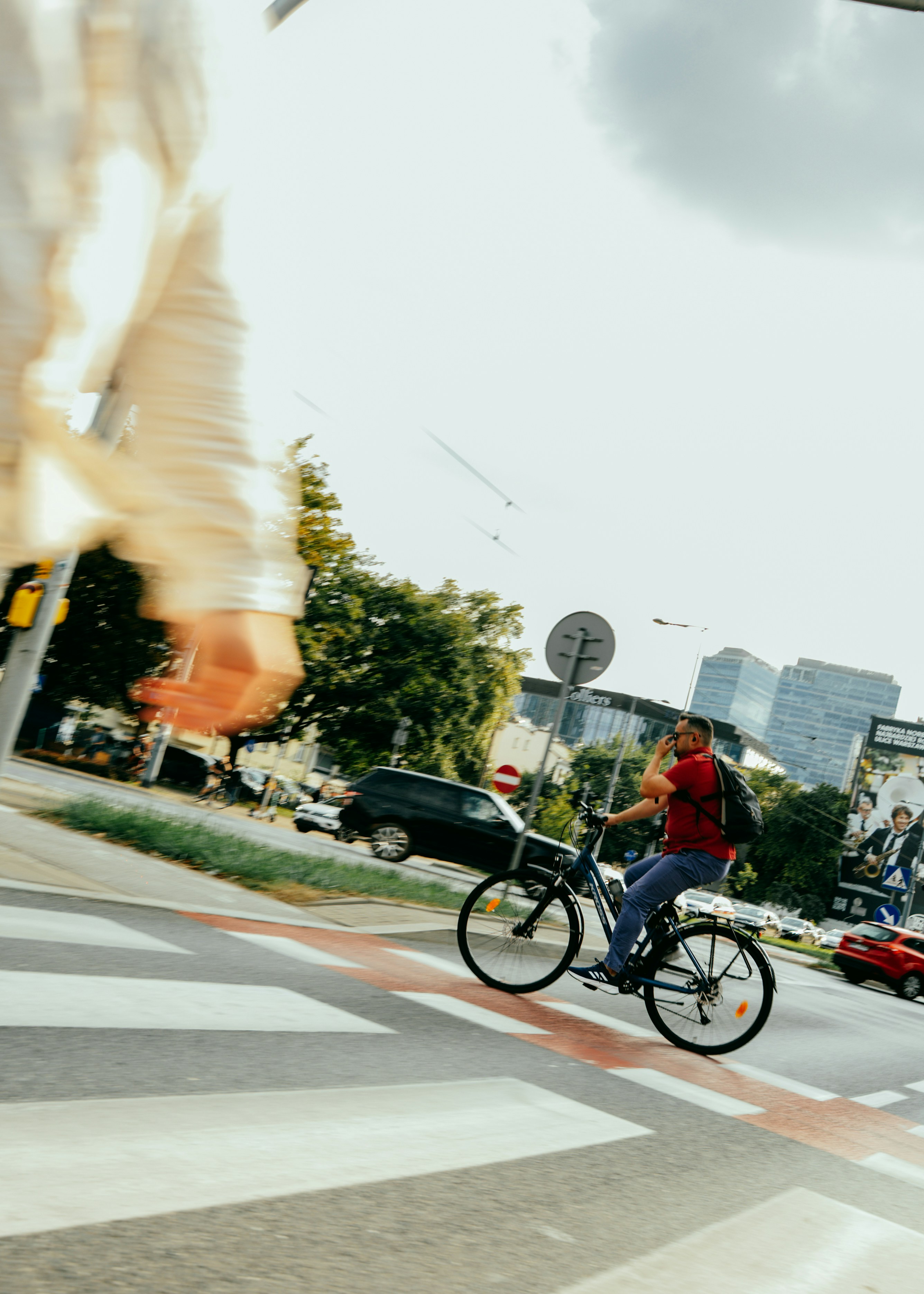 Cyclist crosses the street in a bustling city.