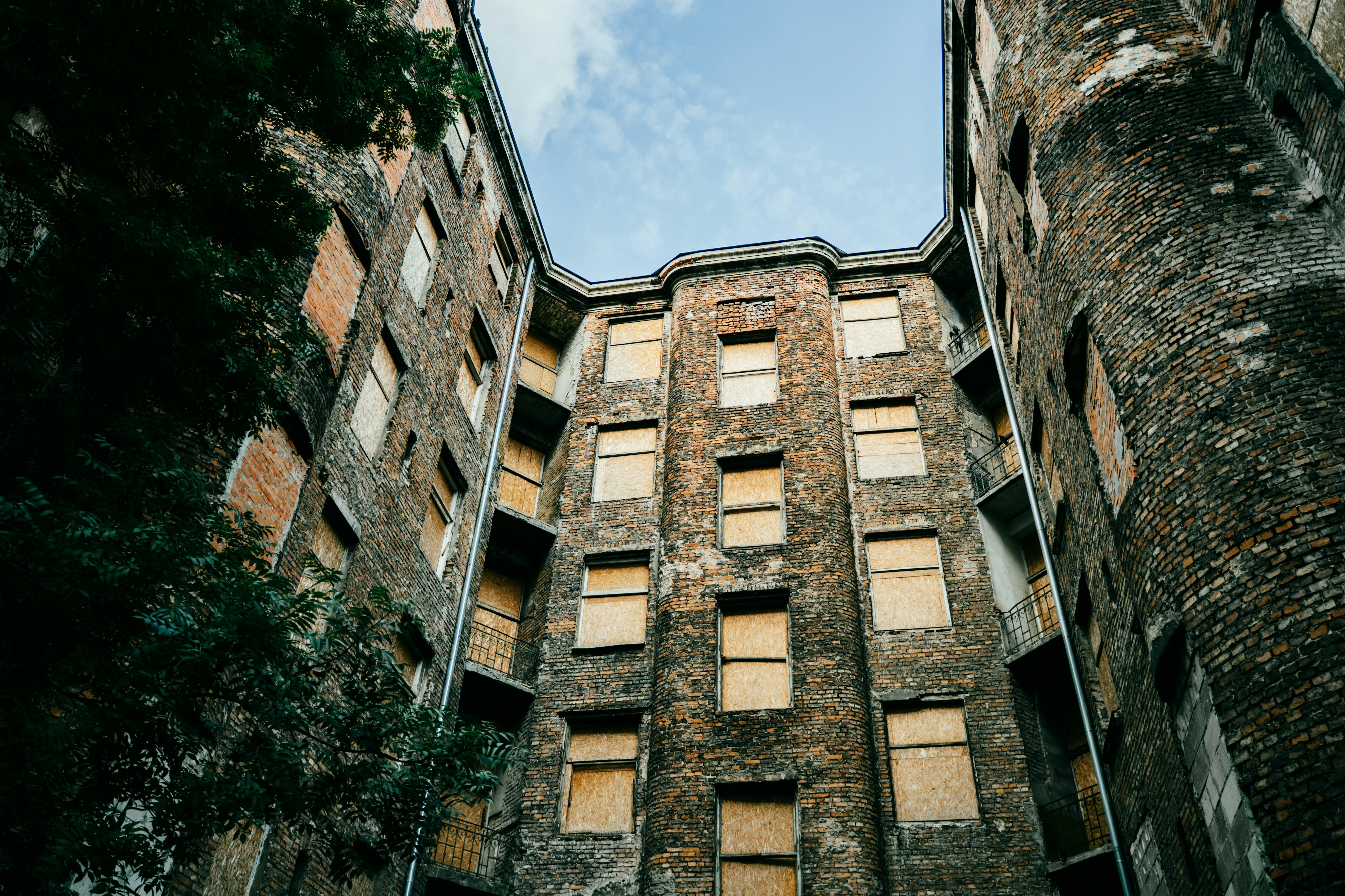 Low angle view of an old, boarded-up building.