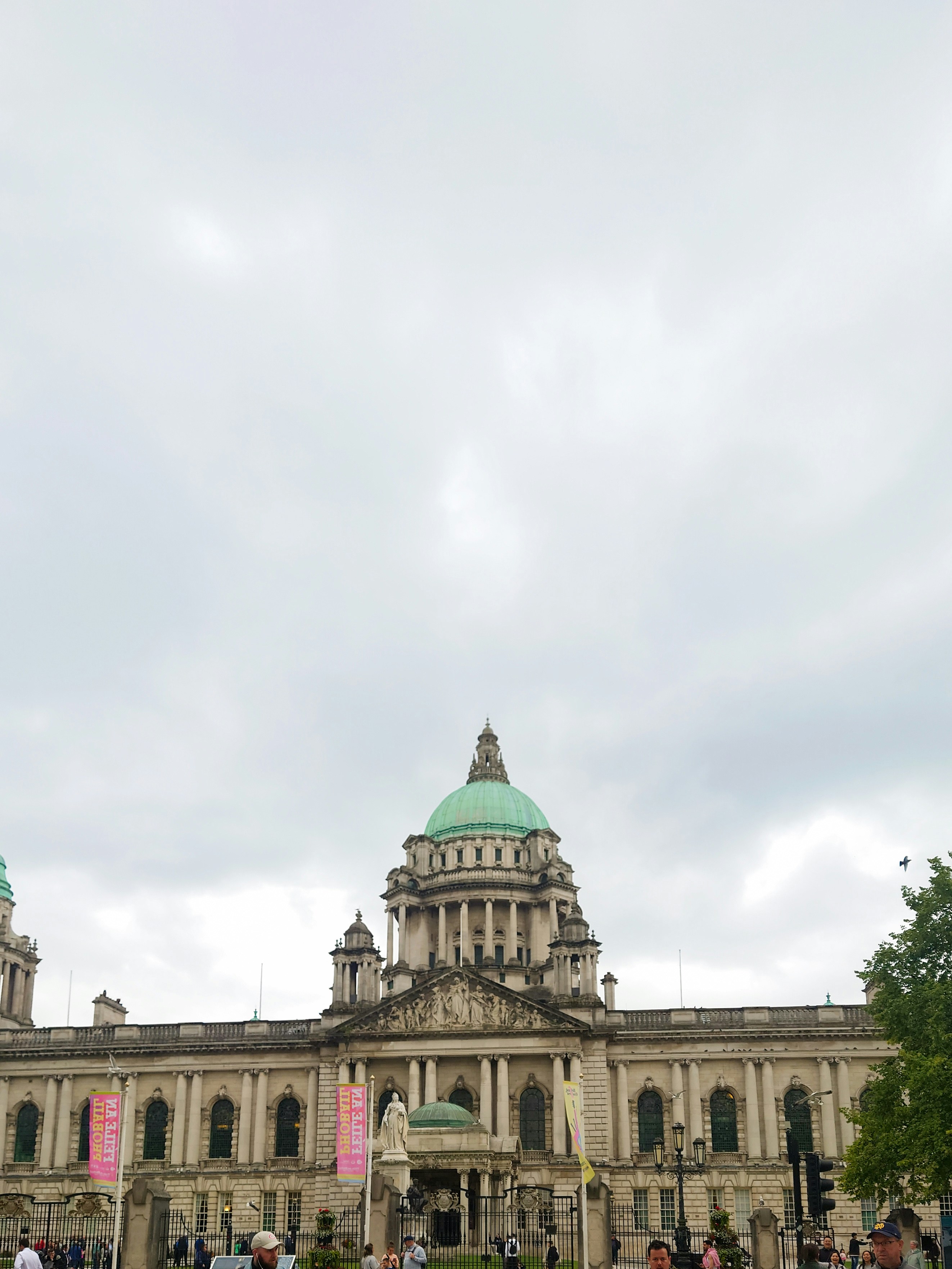 City hall stands tall beneath a cloudy sky.