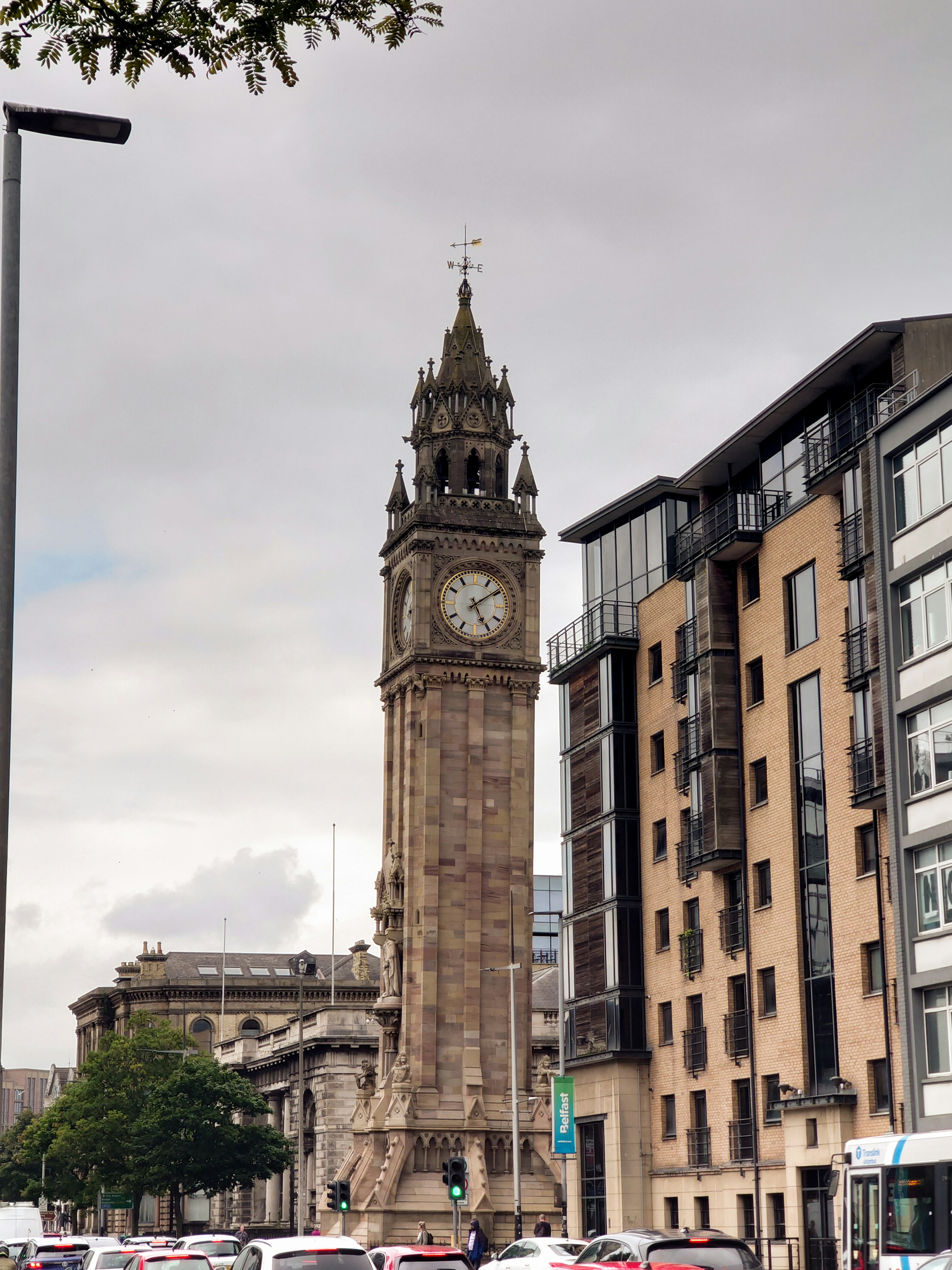 Historic clock tower stands proudly amidst modern architecture, showcasing a blend of old and new in the cityscape.