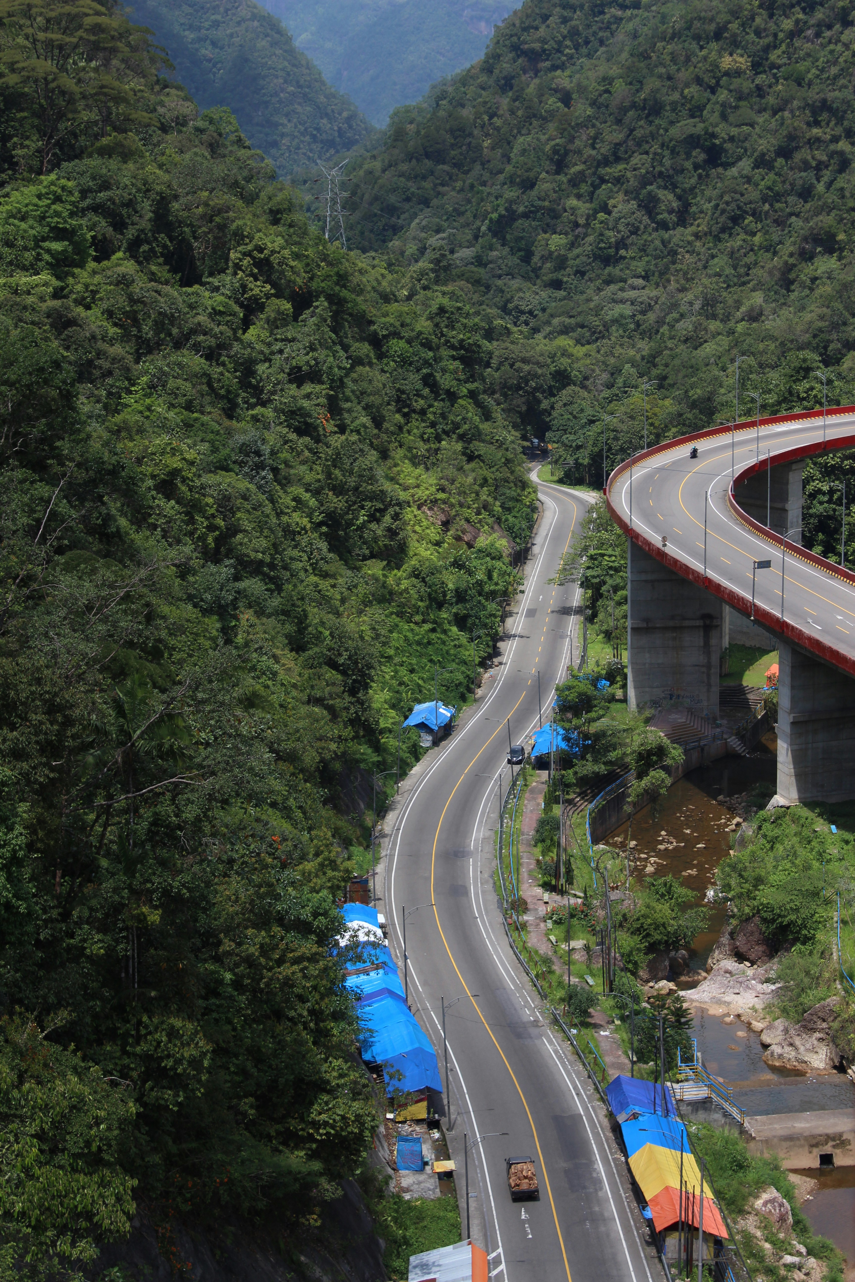 Road winds through a lush, green valley.