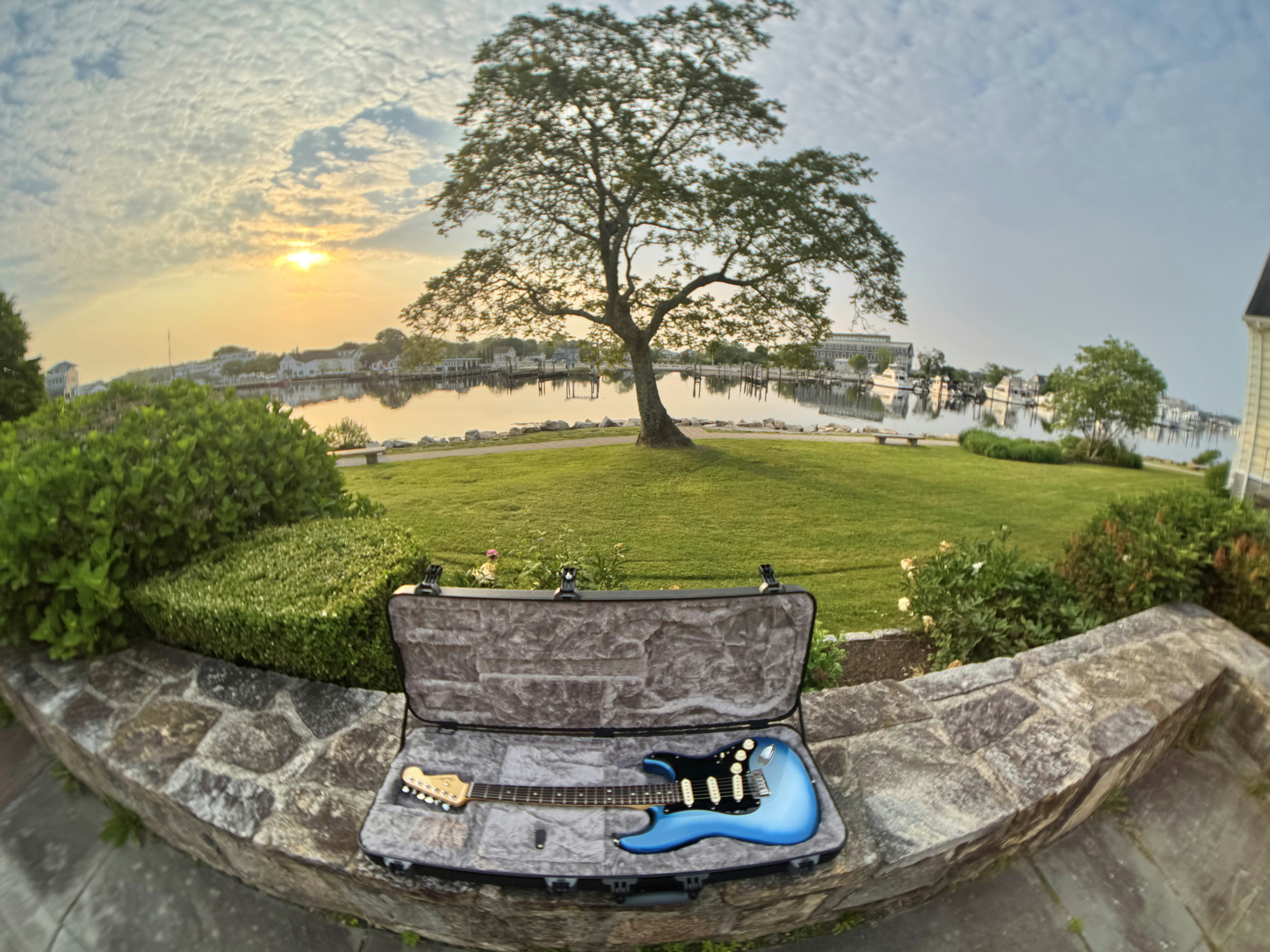 Sky-burst blue Fender Stratocaster sunrise over the Mystic river. | Guitar in a case with a scenic background.