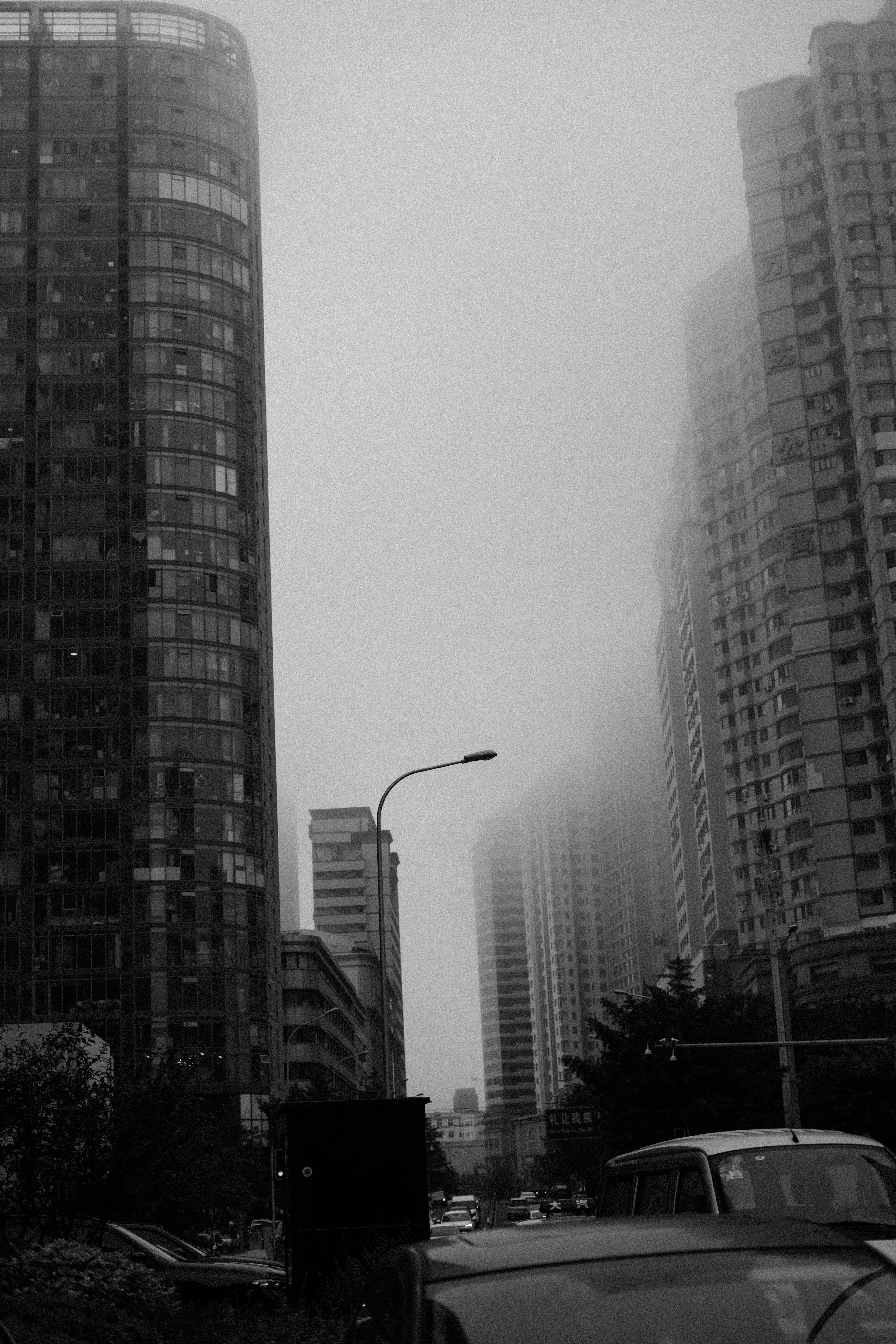 Fog shrouds tall buildings in a city street.