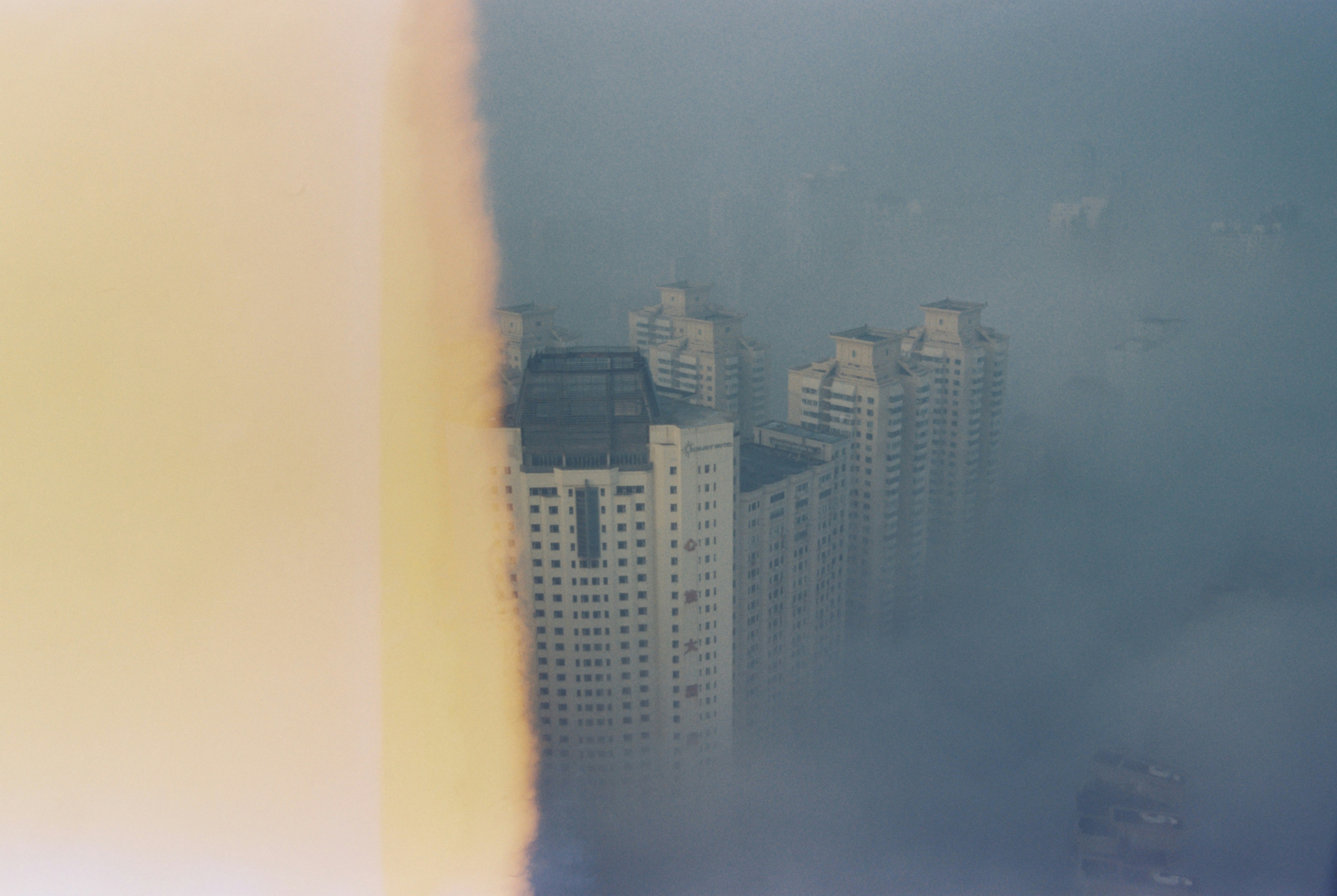 Buildings peeking out from misty, cloudy air.