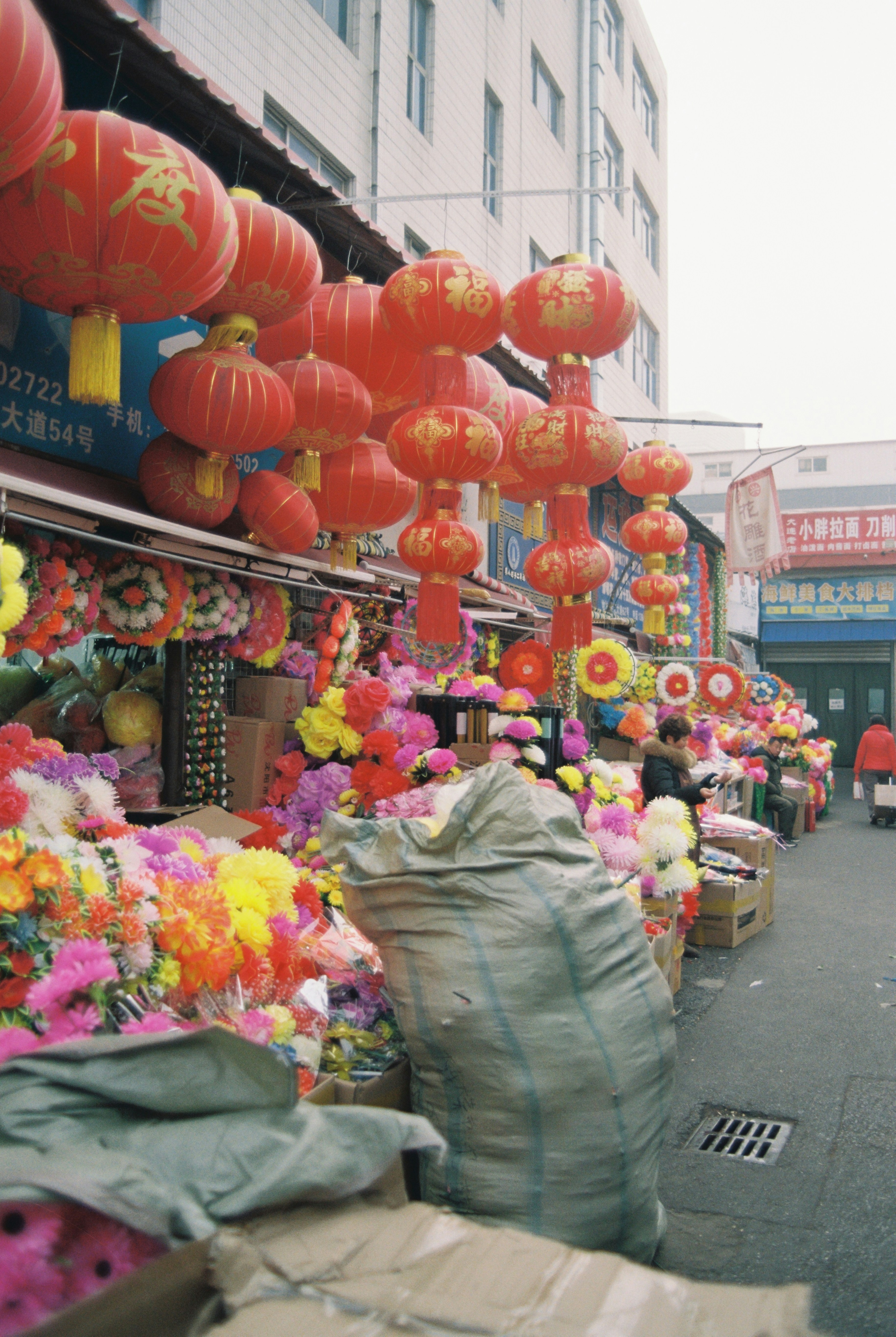 A chinese market is decorated with red lanterns.