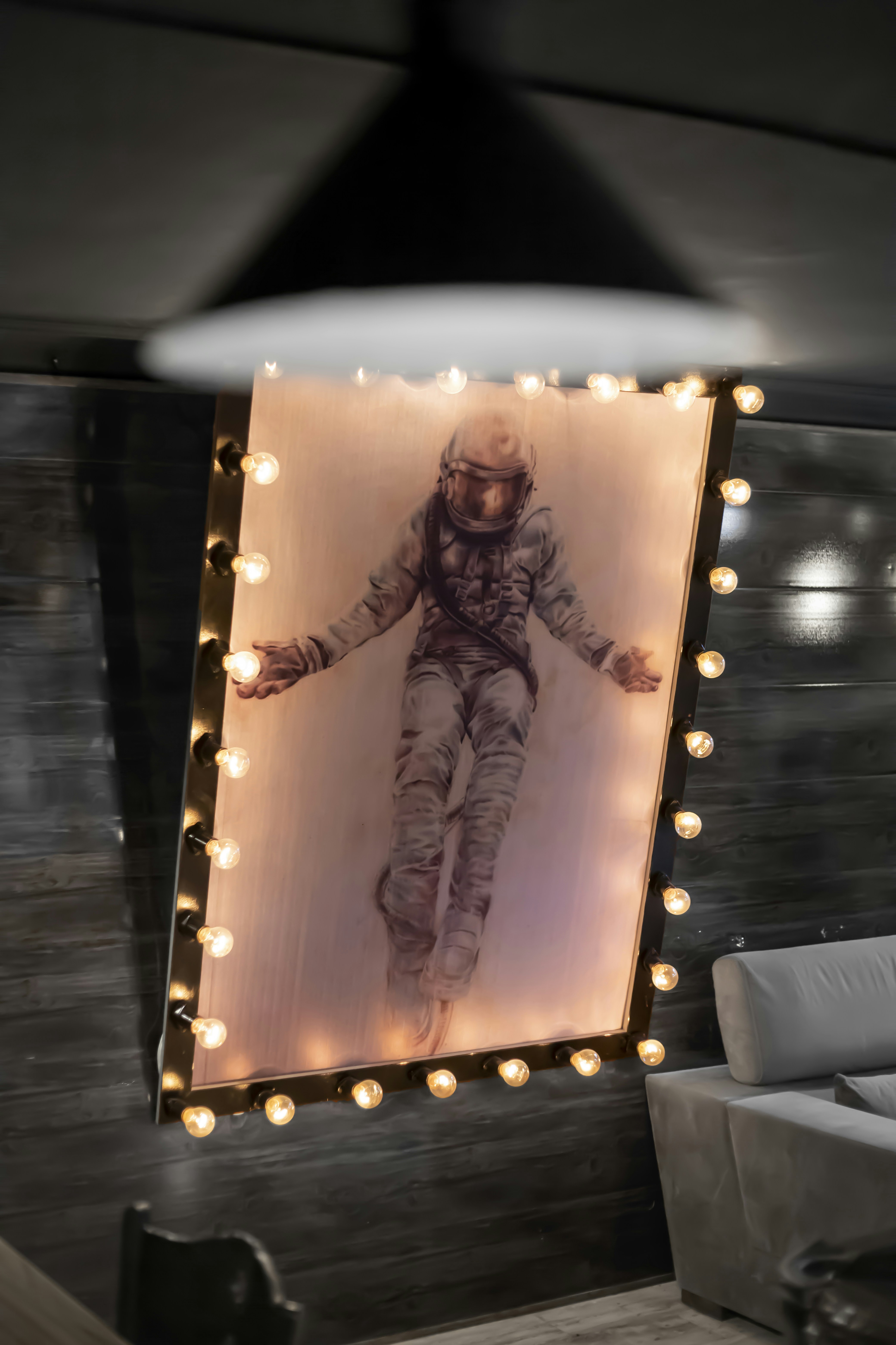 Glow-Frame Astronaut: A Bulb-Marquee Portrait on a Dark Wall
