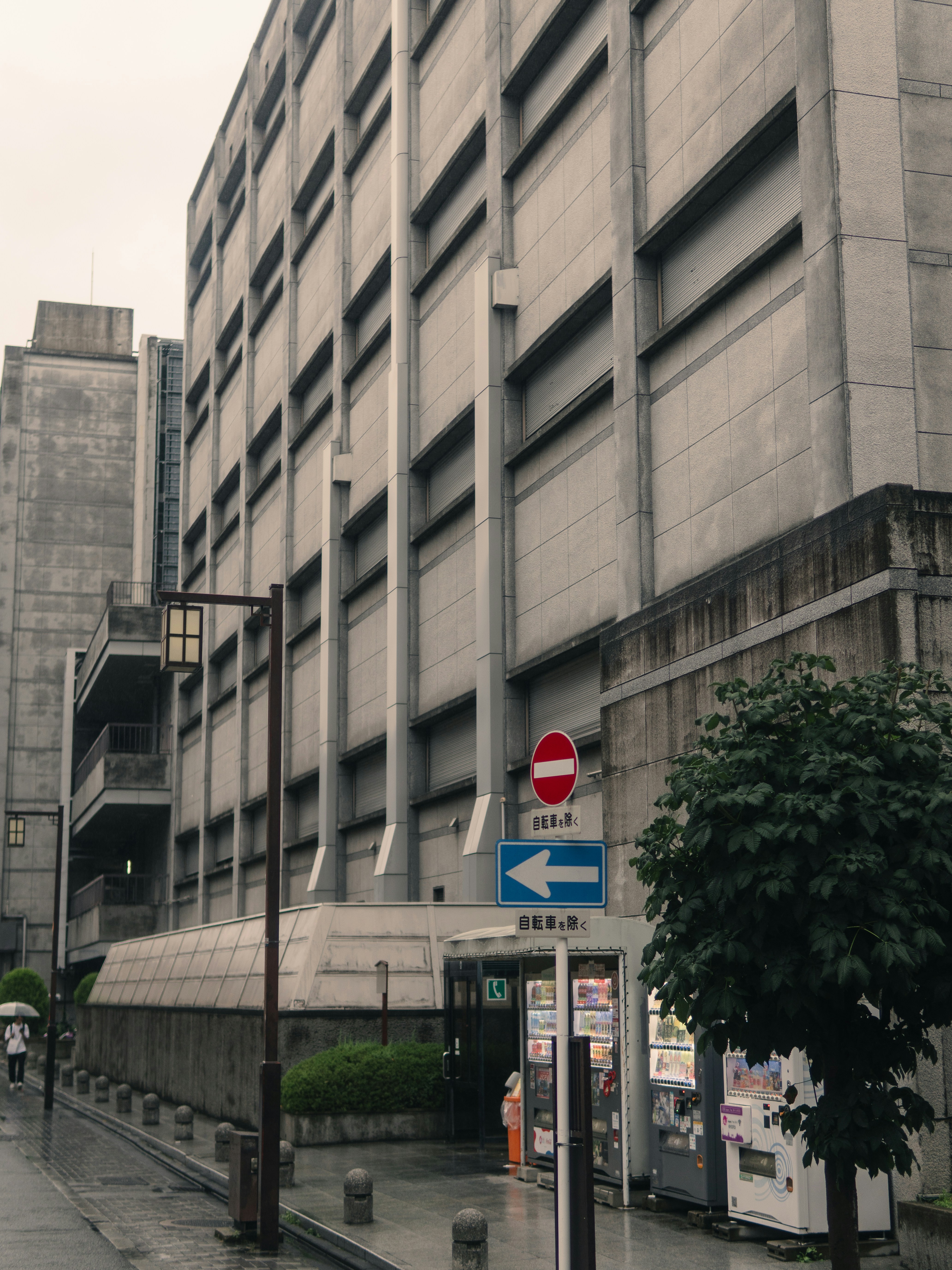 Gray, industrial building stands tall on a rainy day.