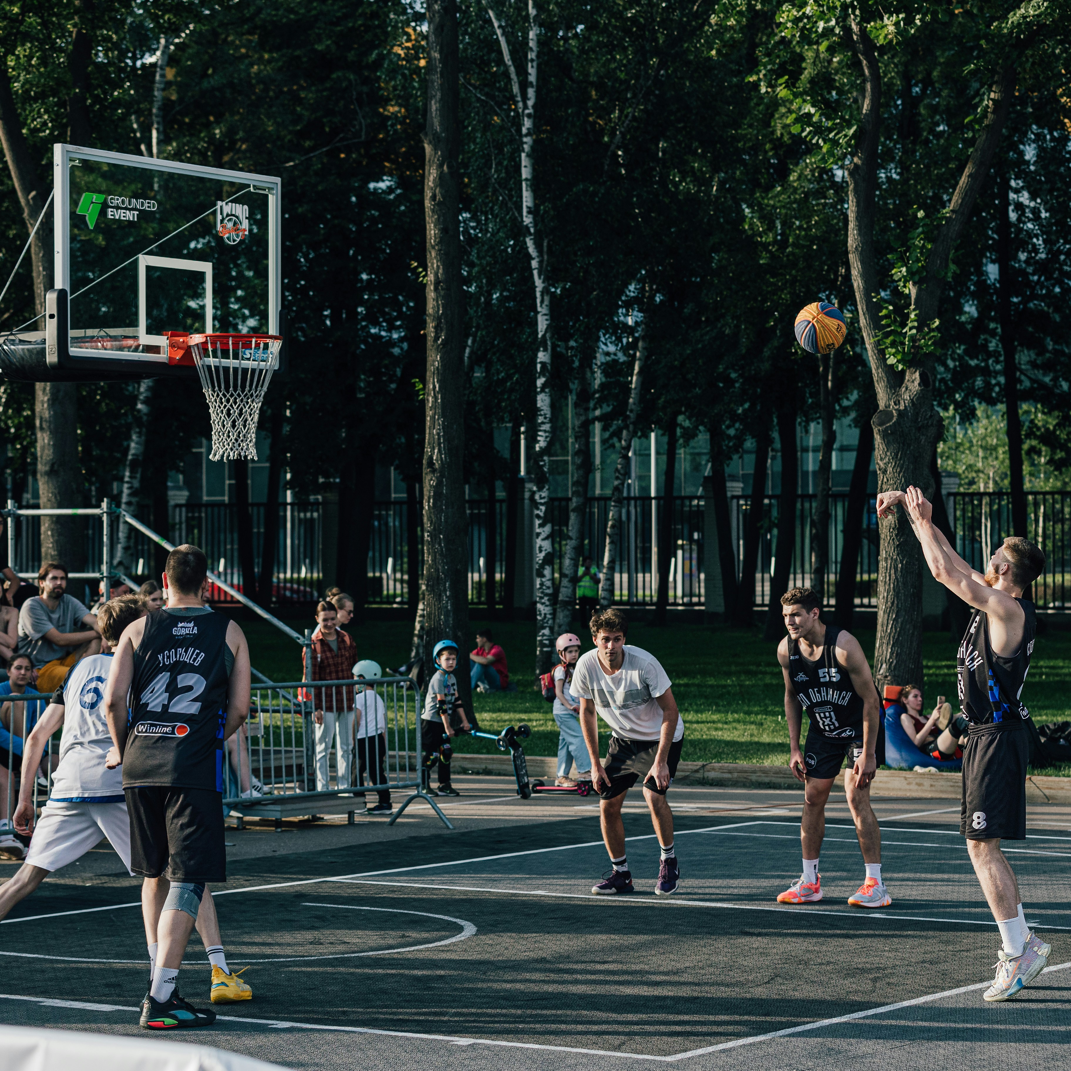 Men playing basketball on an outdoor court