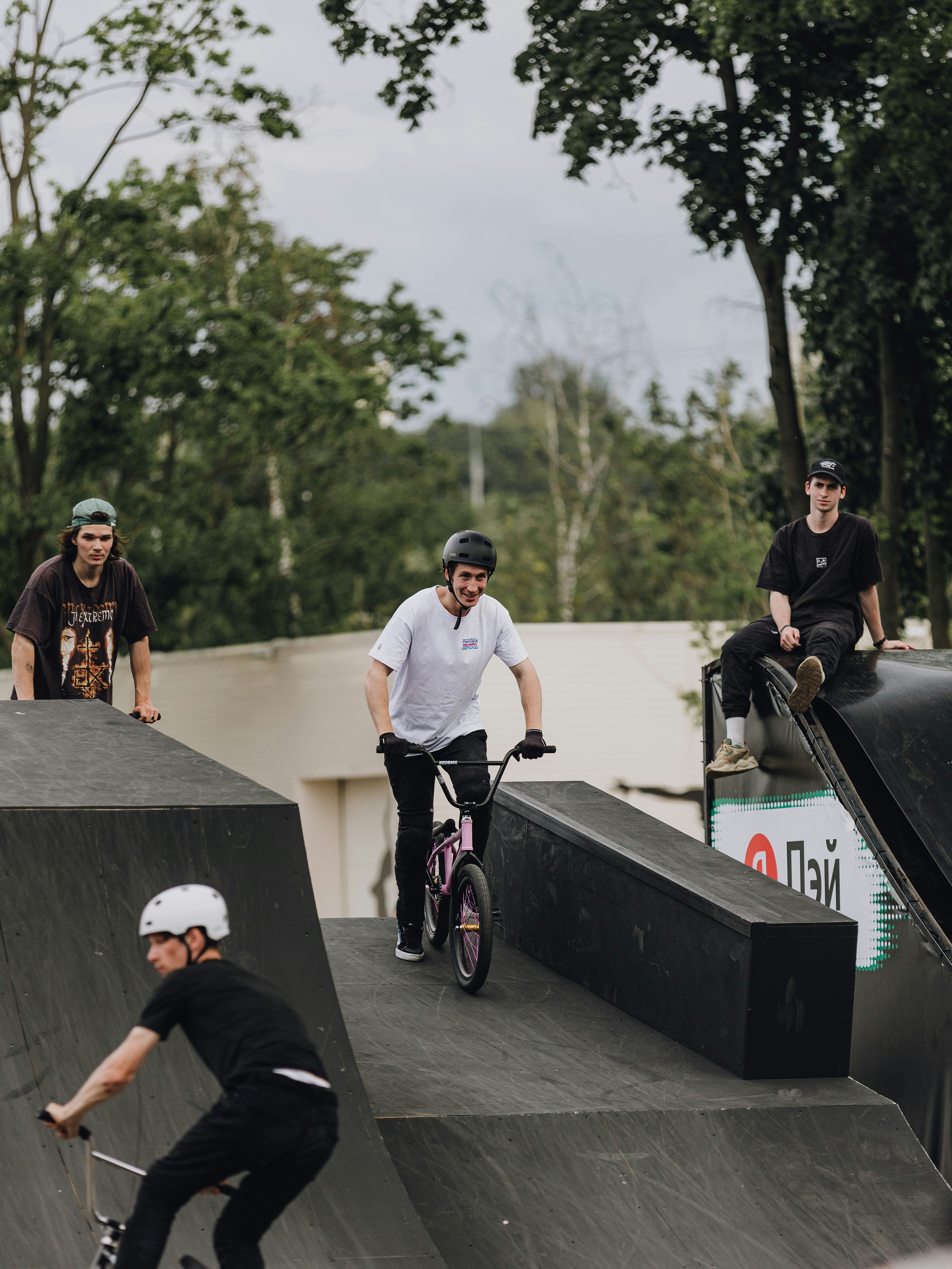 Young men riding bmx bikes at a skatepark.