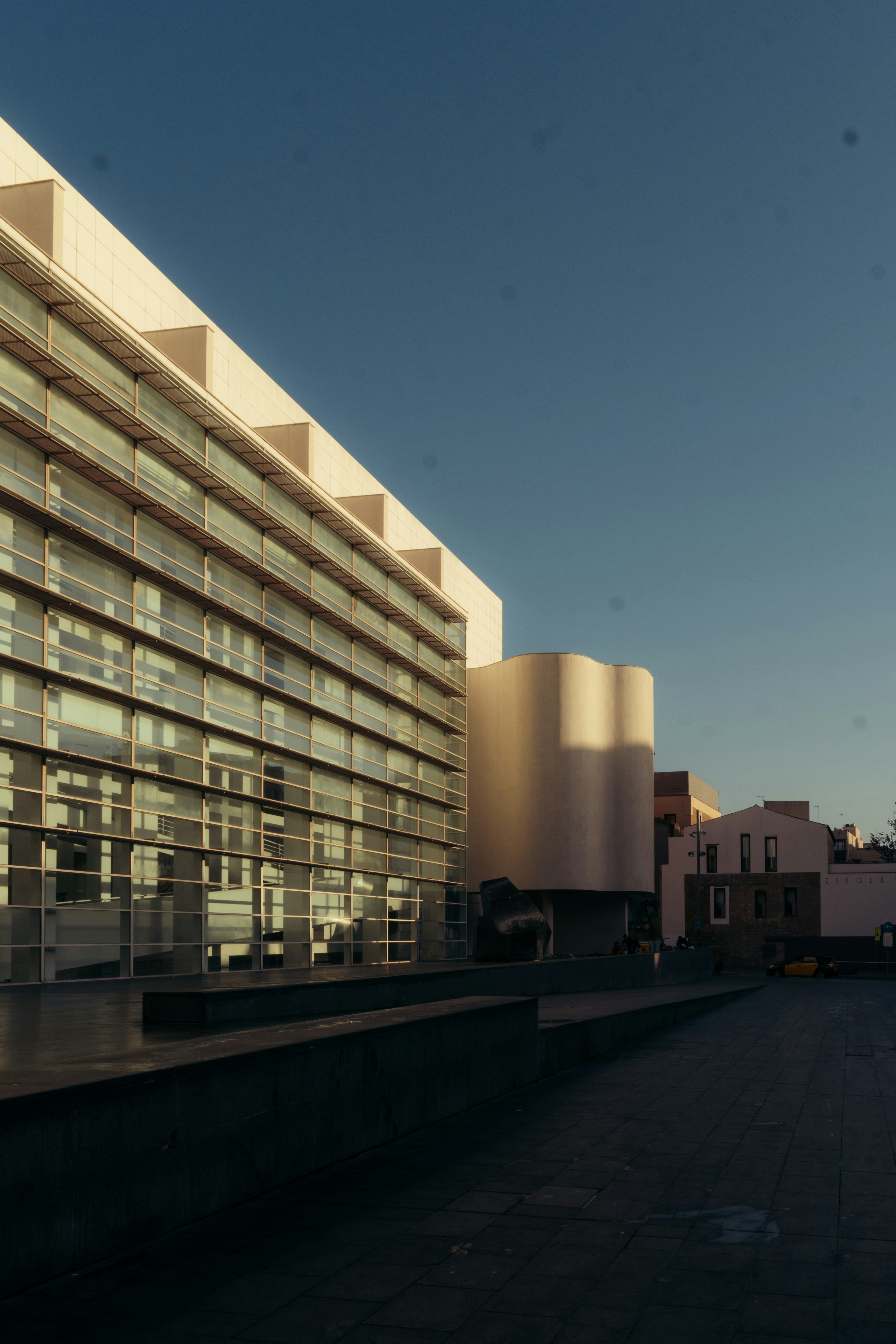 Modern building with glass facade against clear blue sky