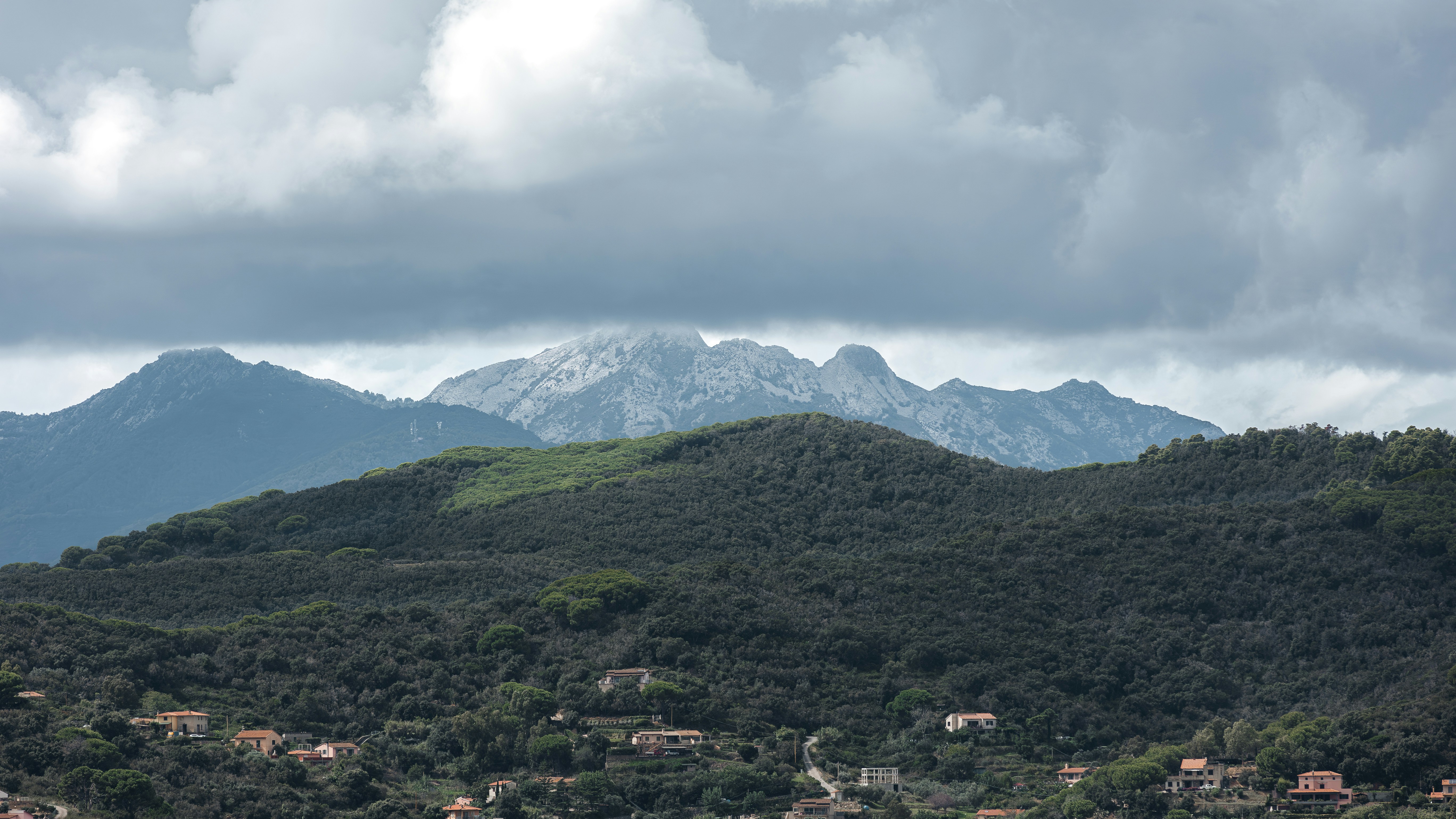 Distant snow-capped mountains under cloudy sky