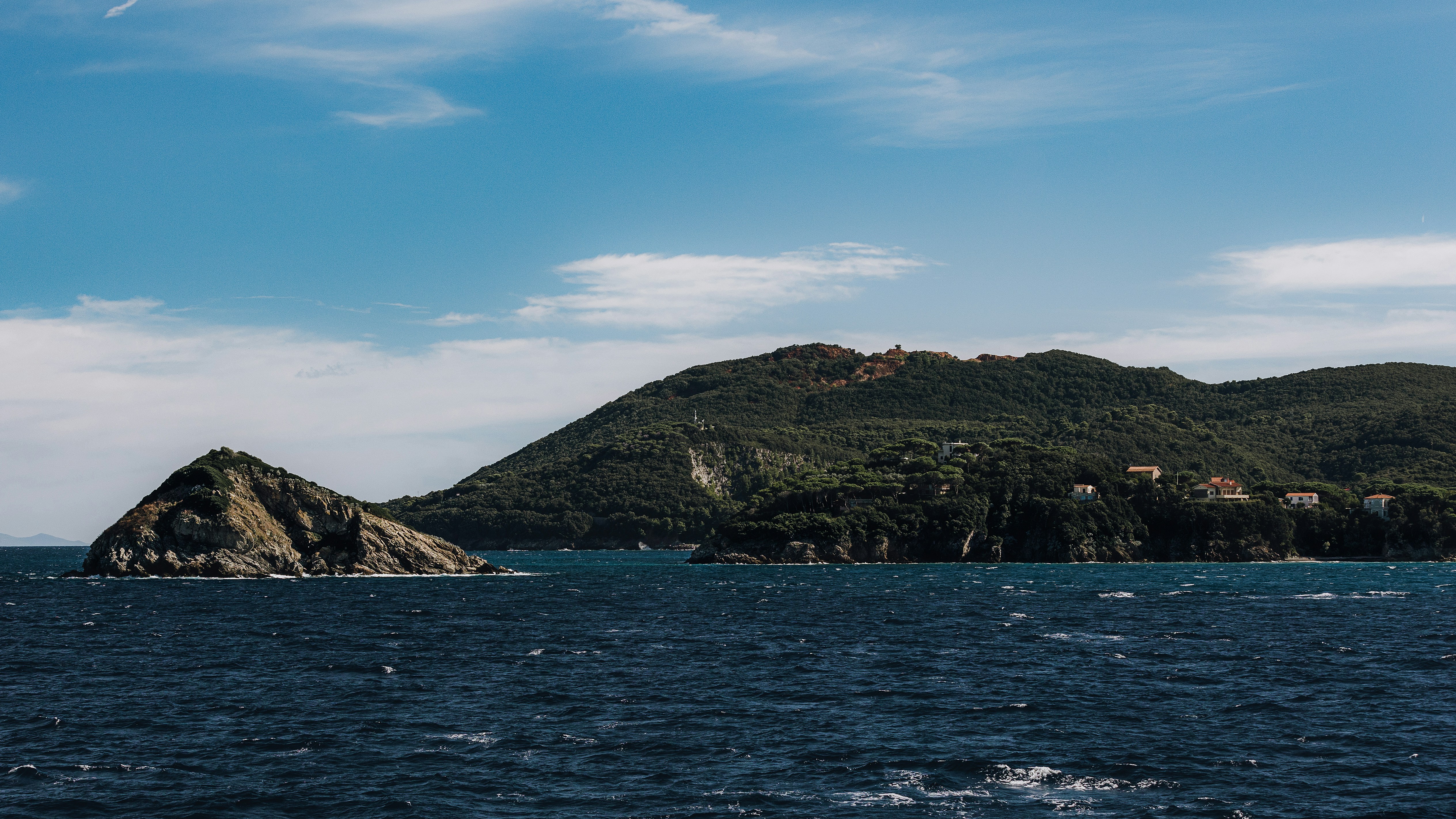 Rocky island and green hills by the sea
