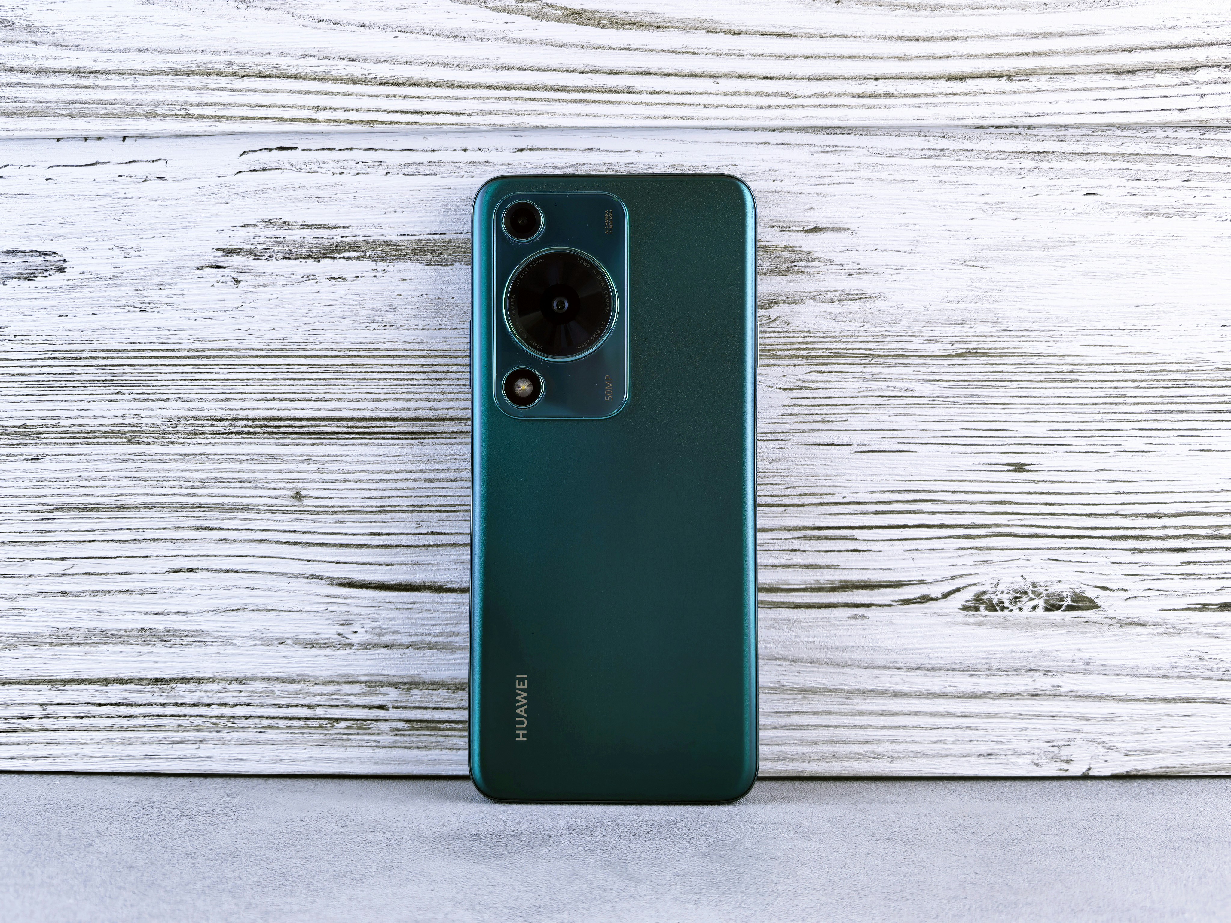 Back of a dark green smartphone with camera