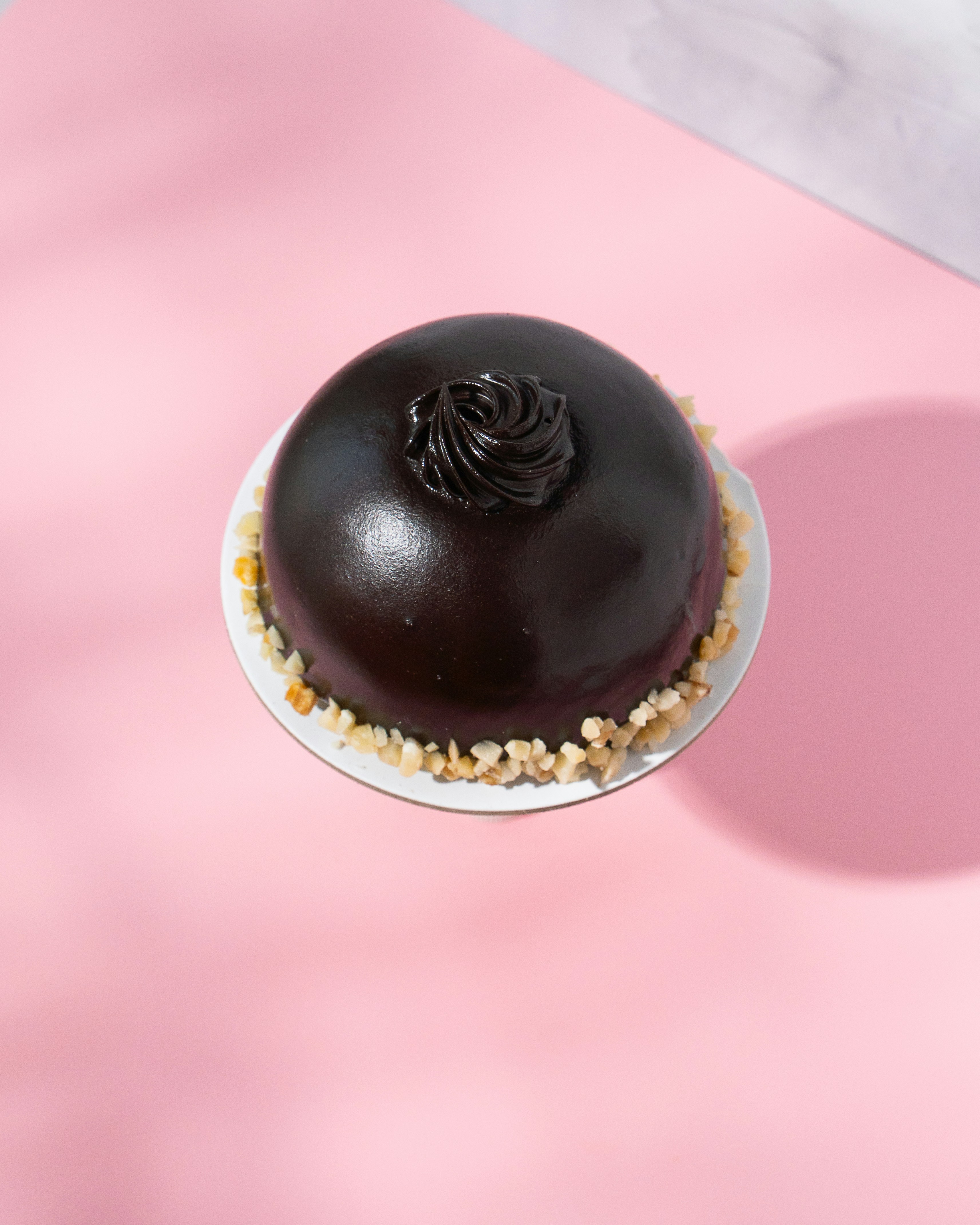 A single chocolate dome cake with nuts