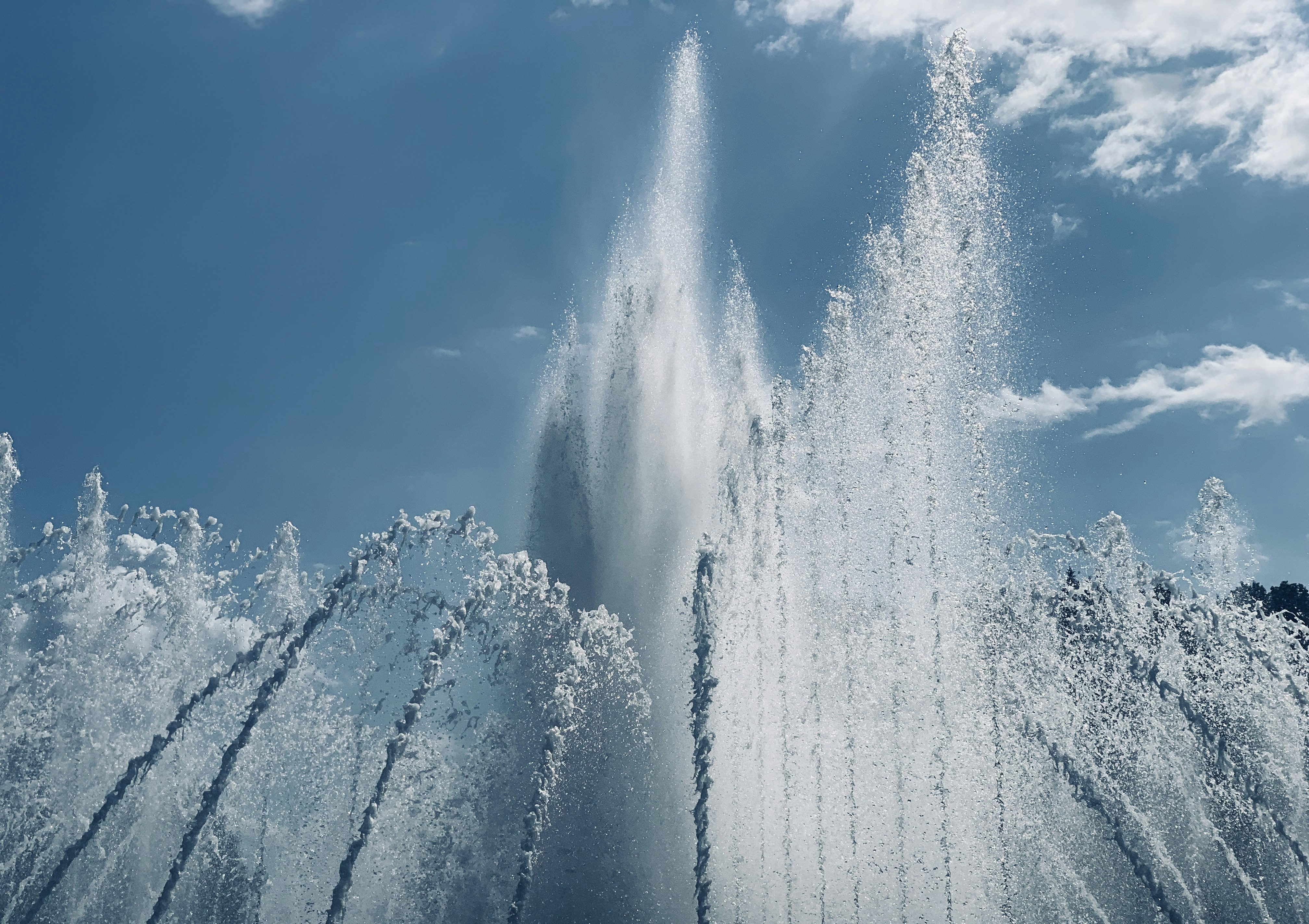 Water spraying from a fountain against a blue sky