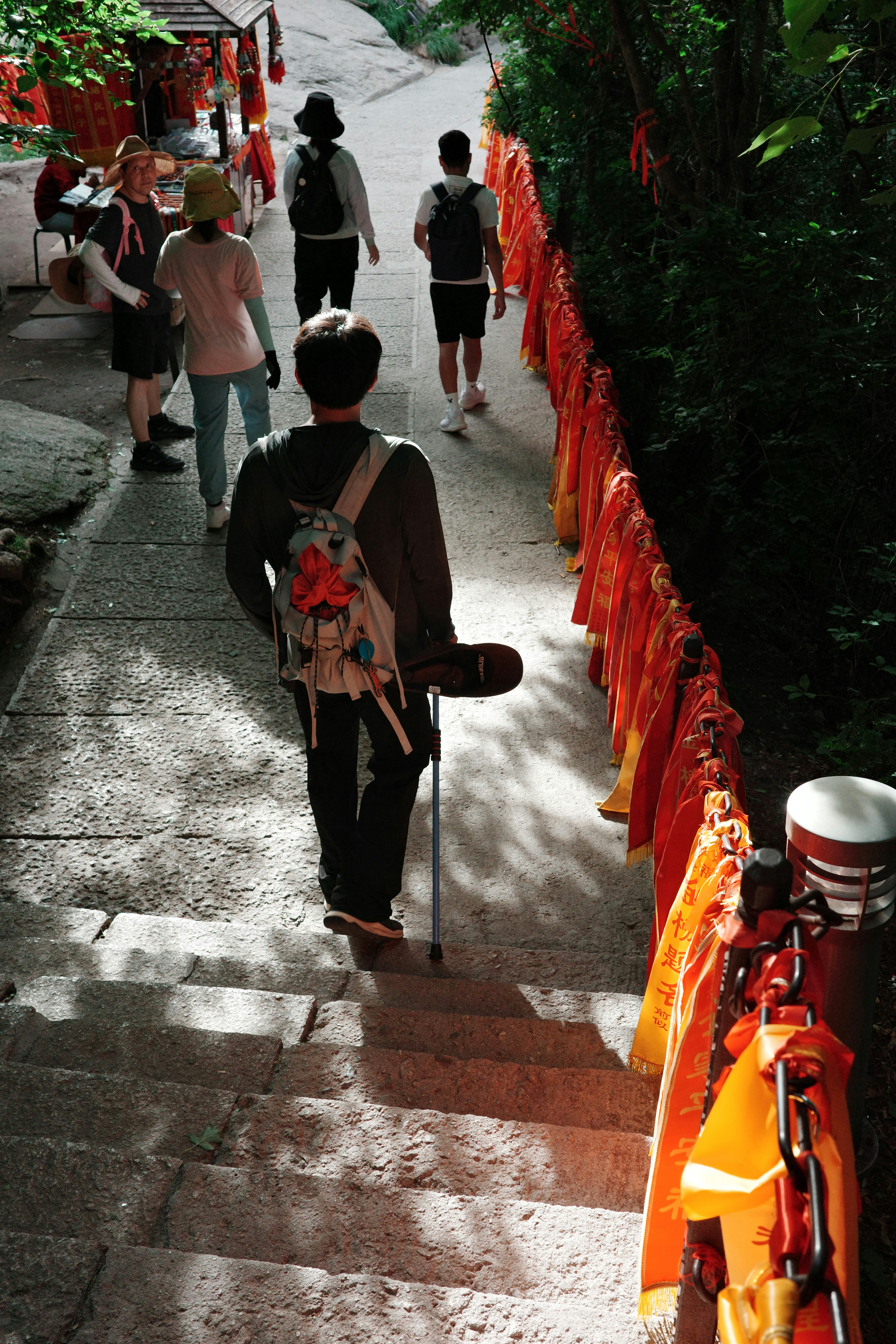 People walking up stone stairs with prayer flags