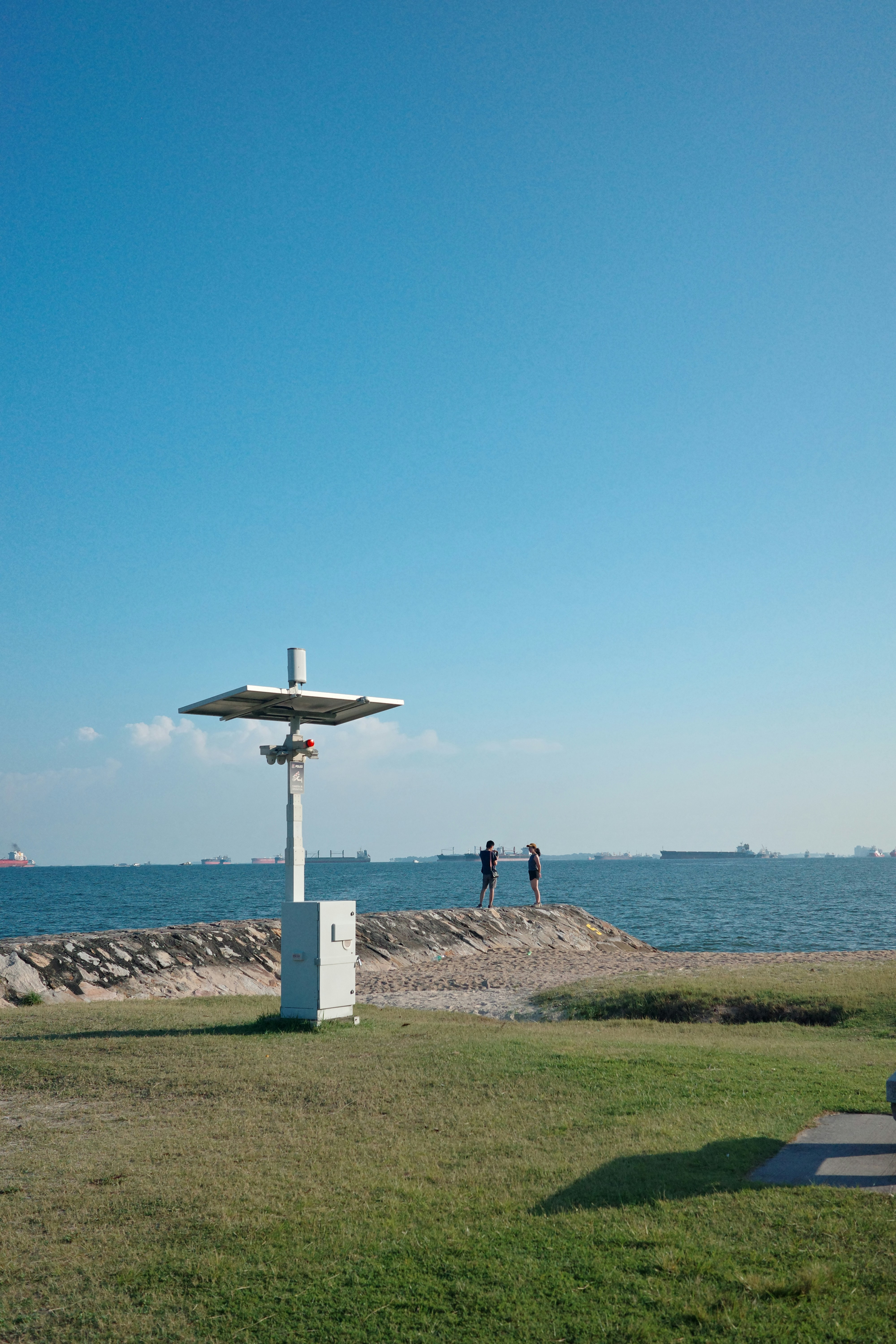 you and me | Two people stand on a breakwater overlooking the sea.