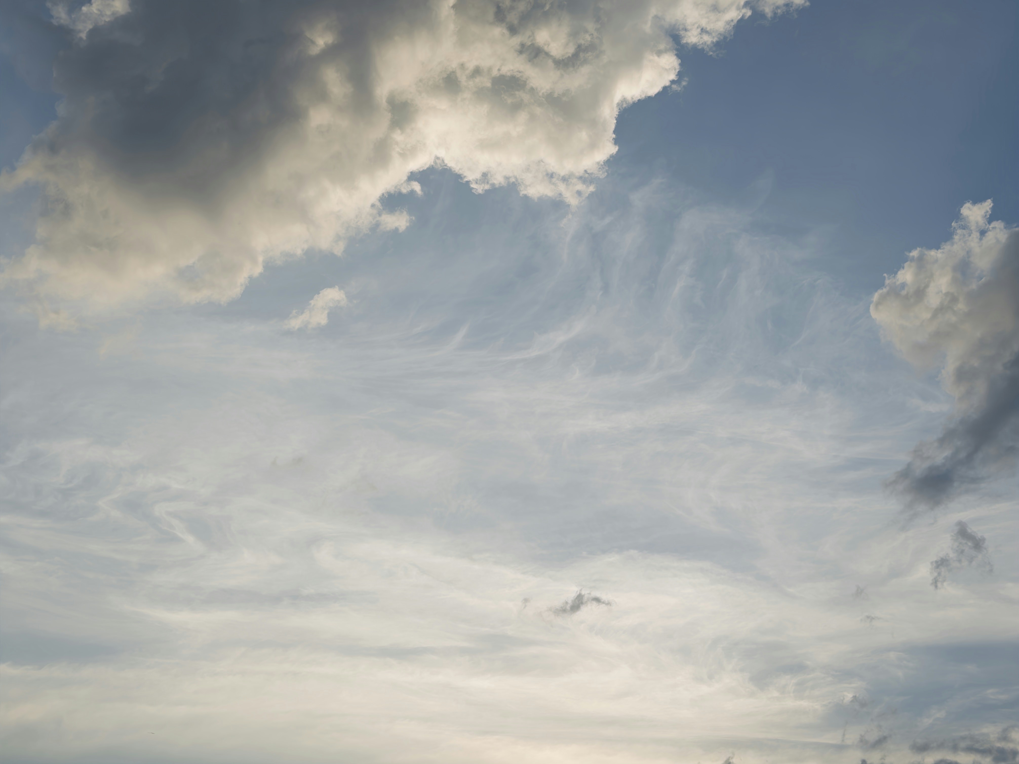 Wispy clouds drift across a bright blue sky