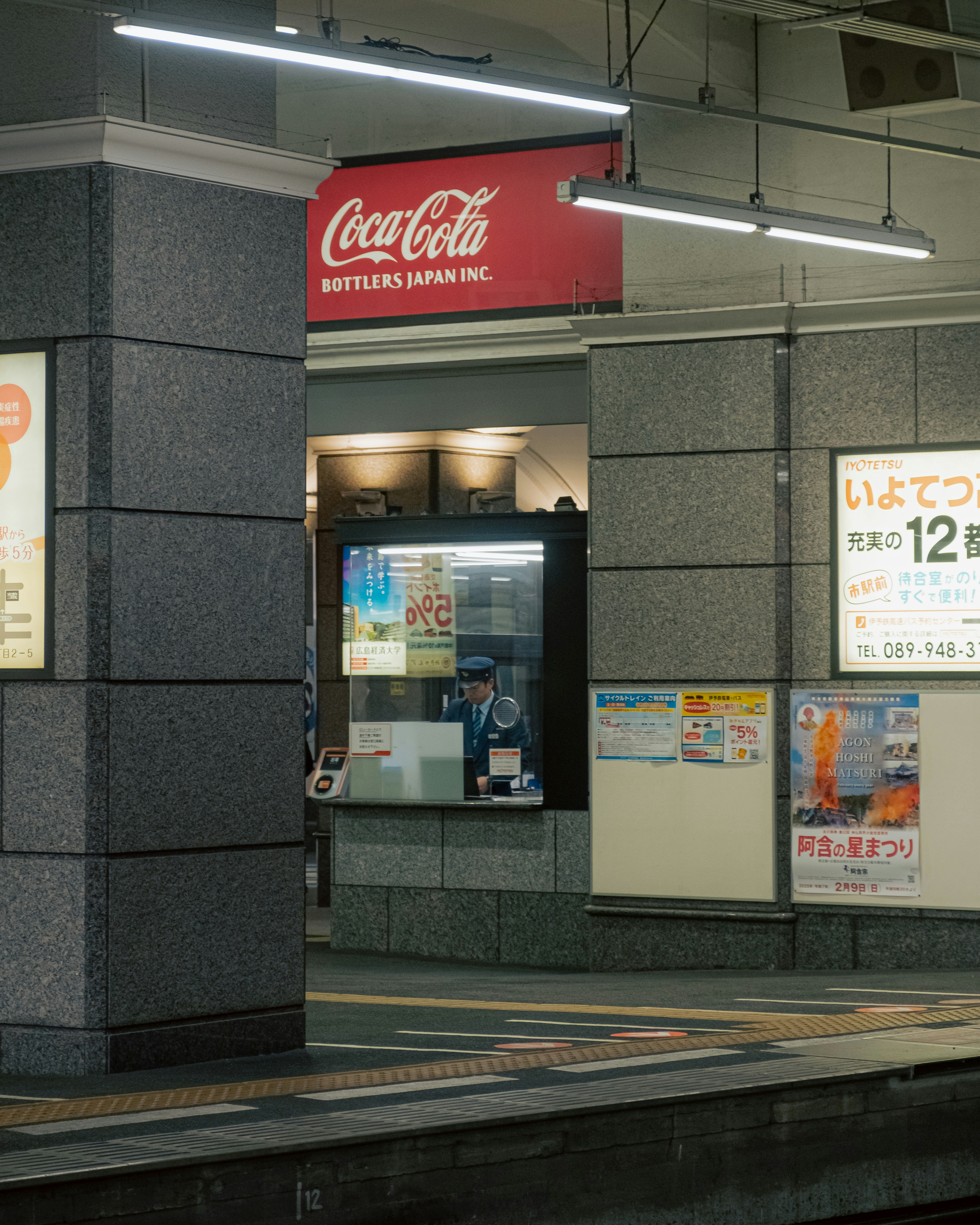 Coca-cola sign above a subway station kiosk