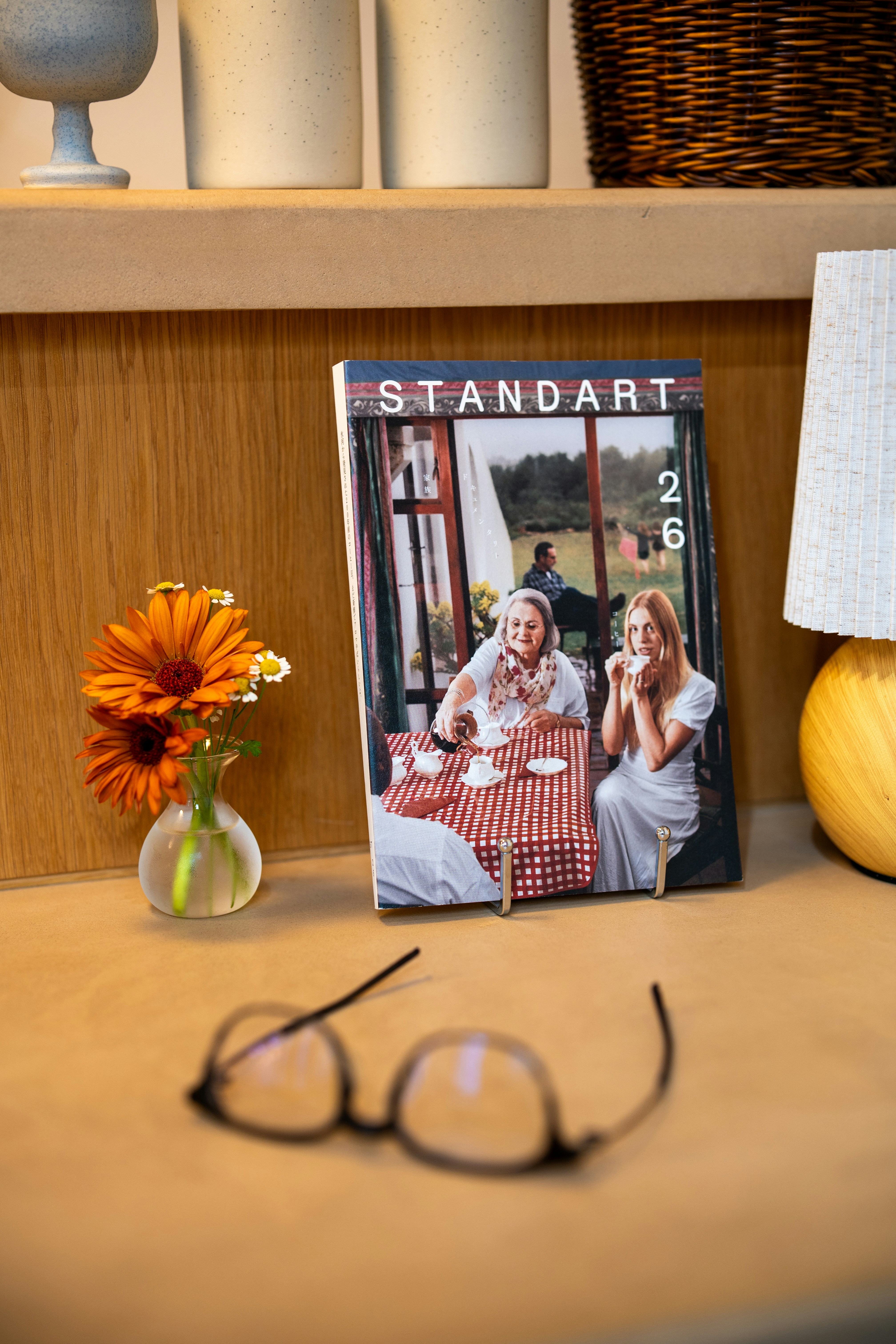 Magazine with flowers and glasses on table