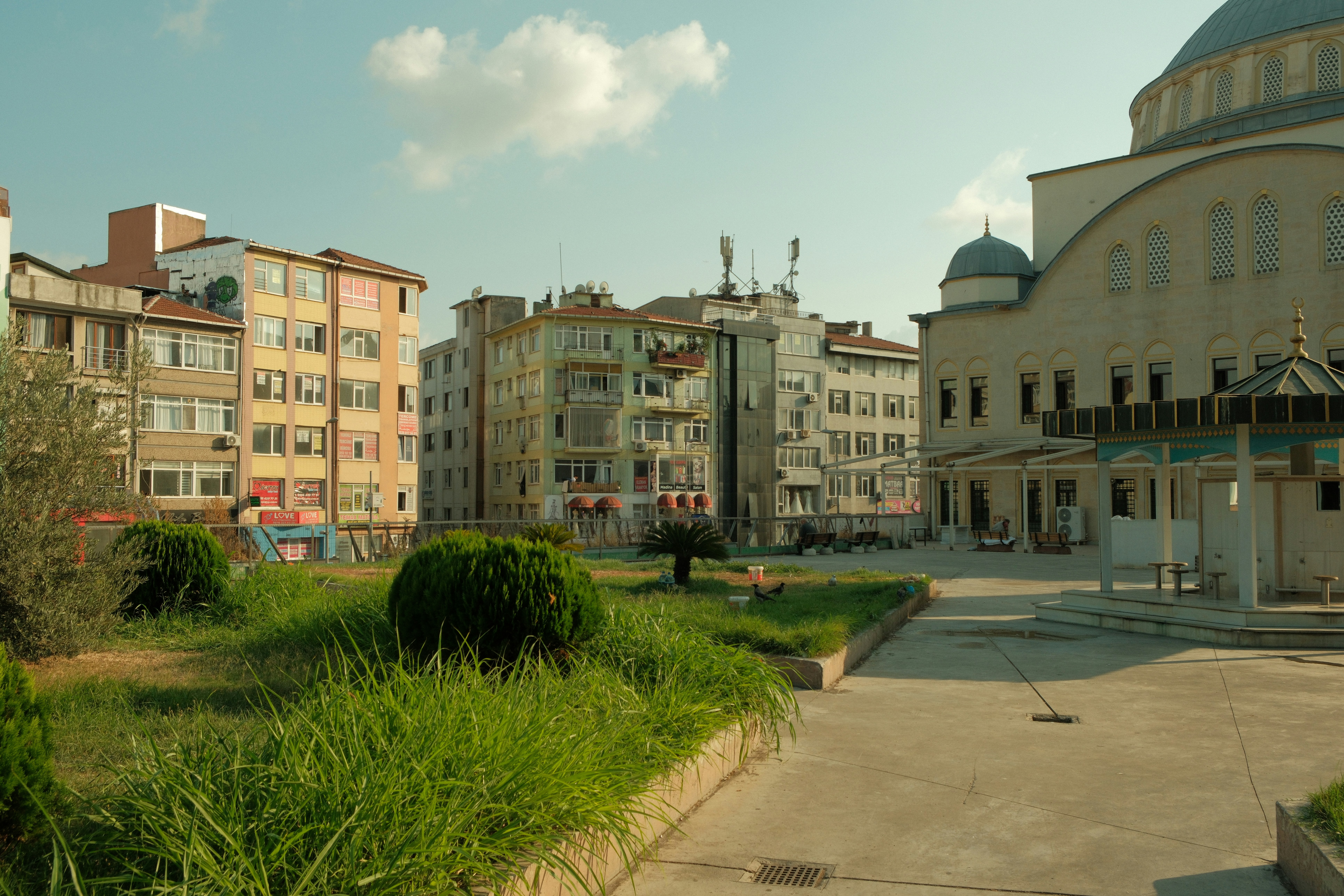Apartment buildings and a domed structure on a sunny day.