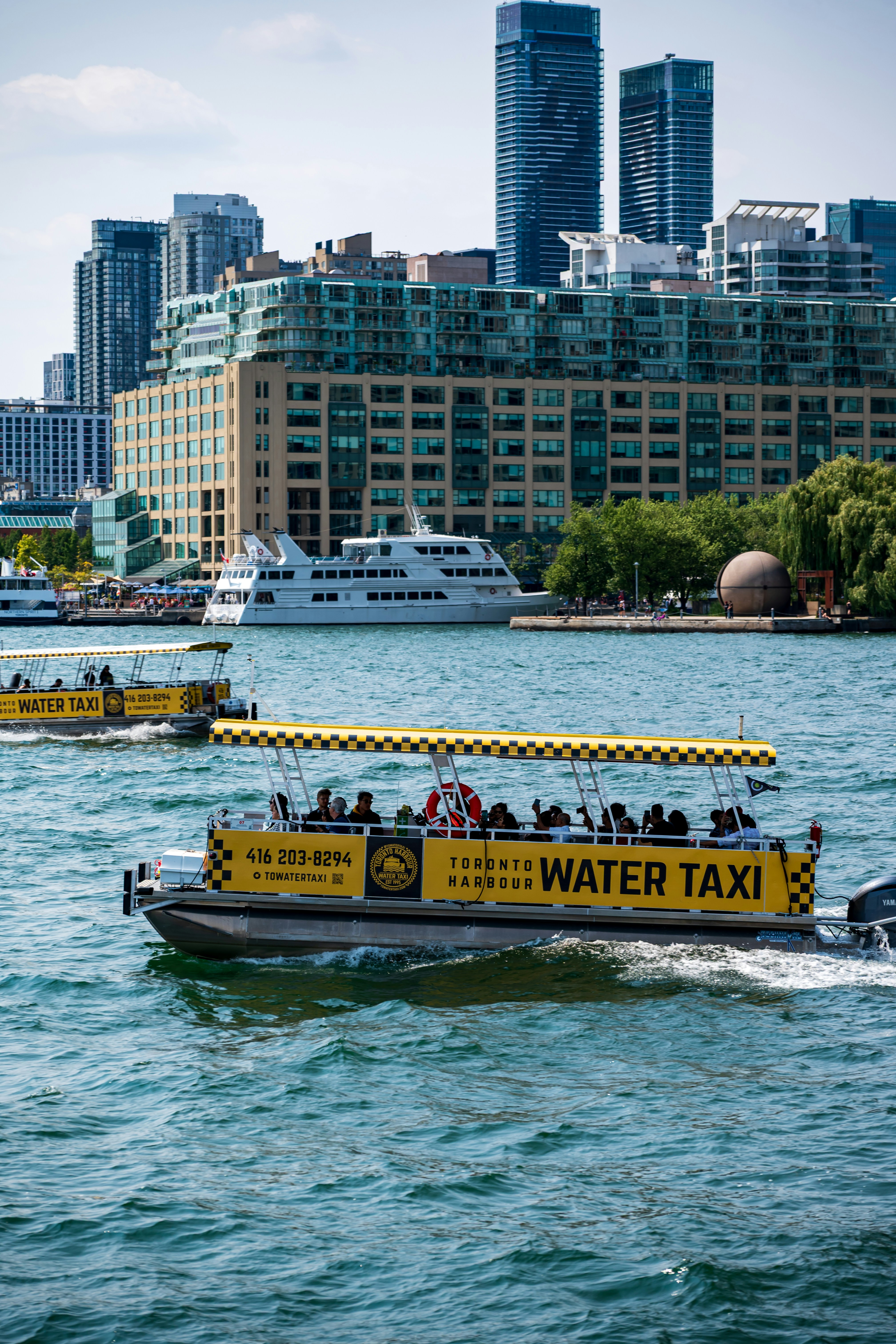 Yellow Water Taxi Slices Through Toronto Harbour Beneath a Modern Skyline
