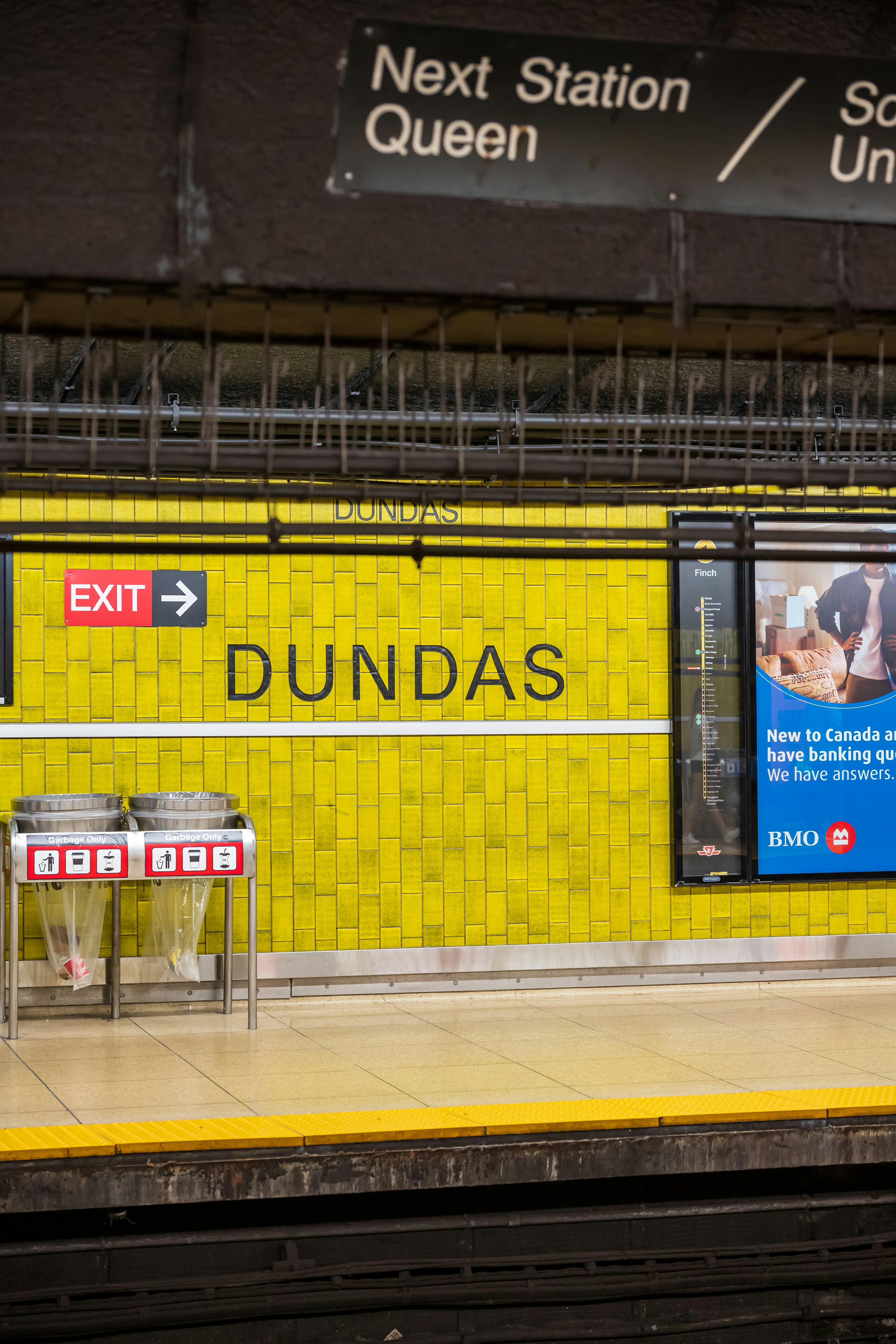 Subway station platform with yellow tiled wall