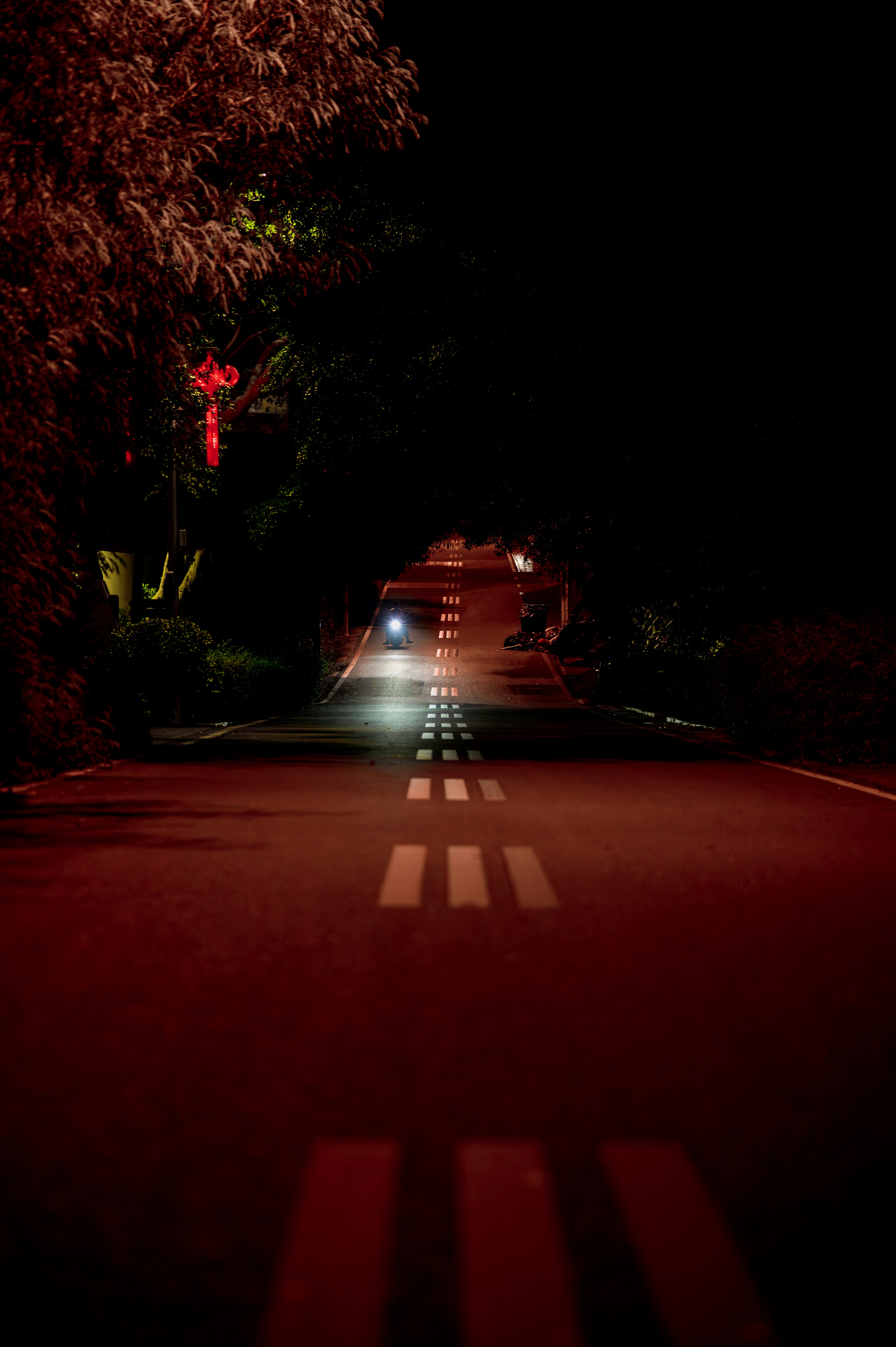 A street at night with red lights and car headlights.