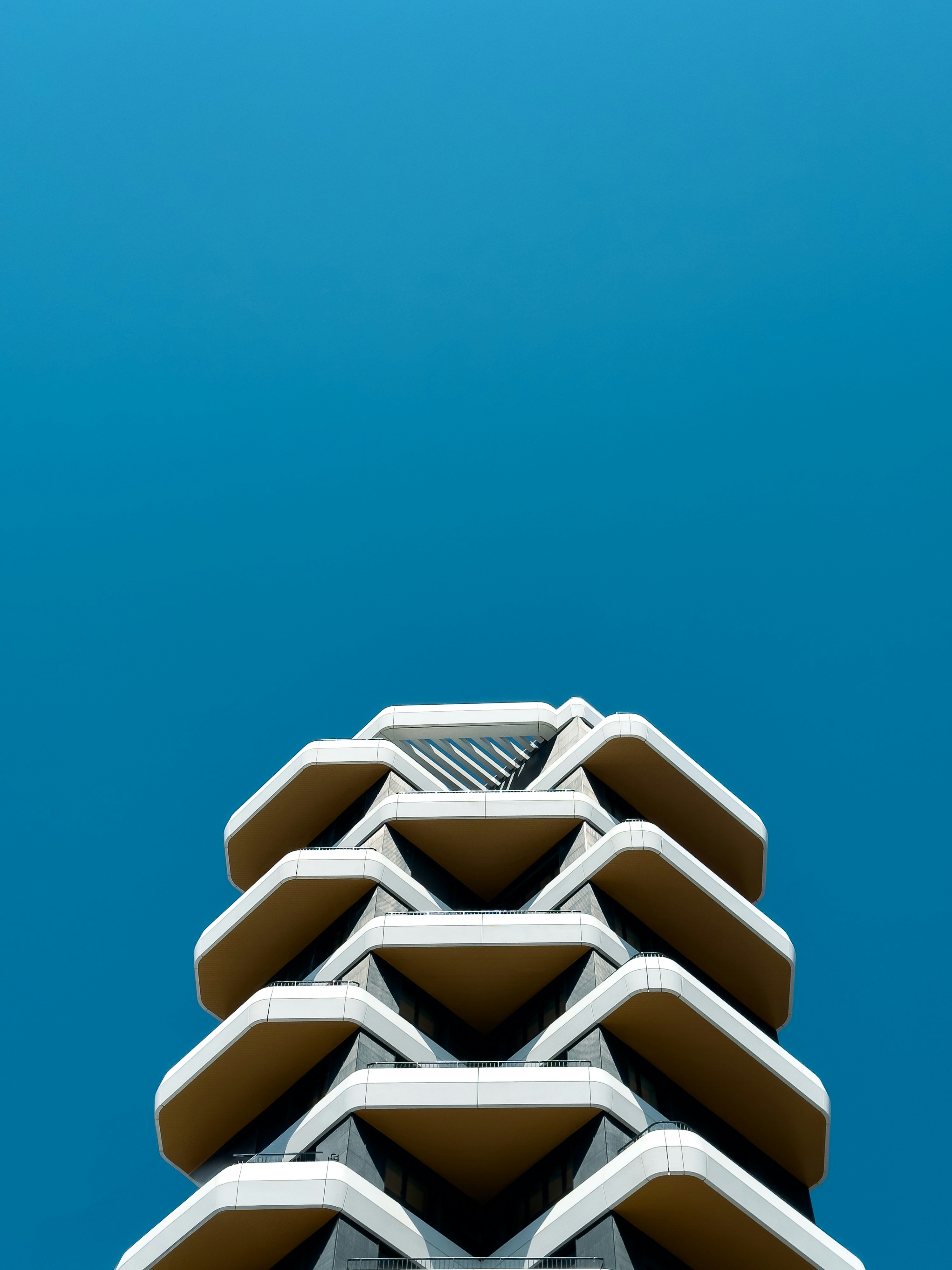 The new apartment building in Lisbon, Portugal. Great temporary architecture | Modern building with unique geometric balconies against blue sky