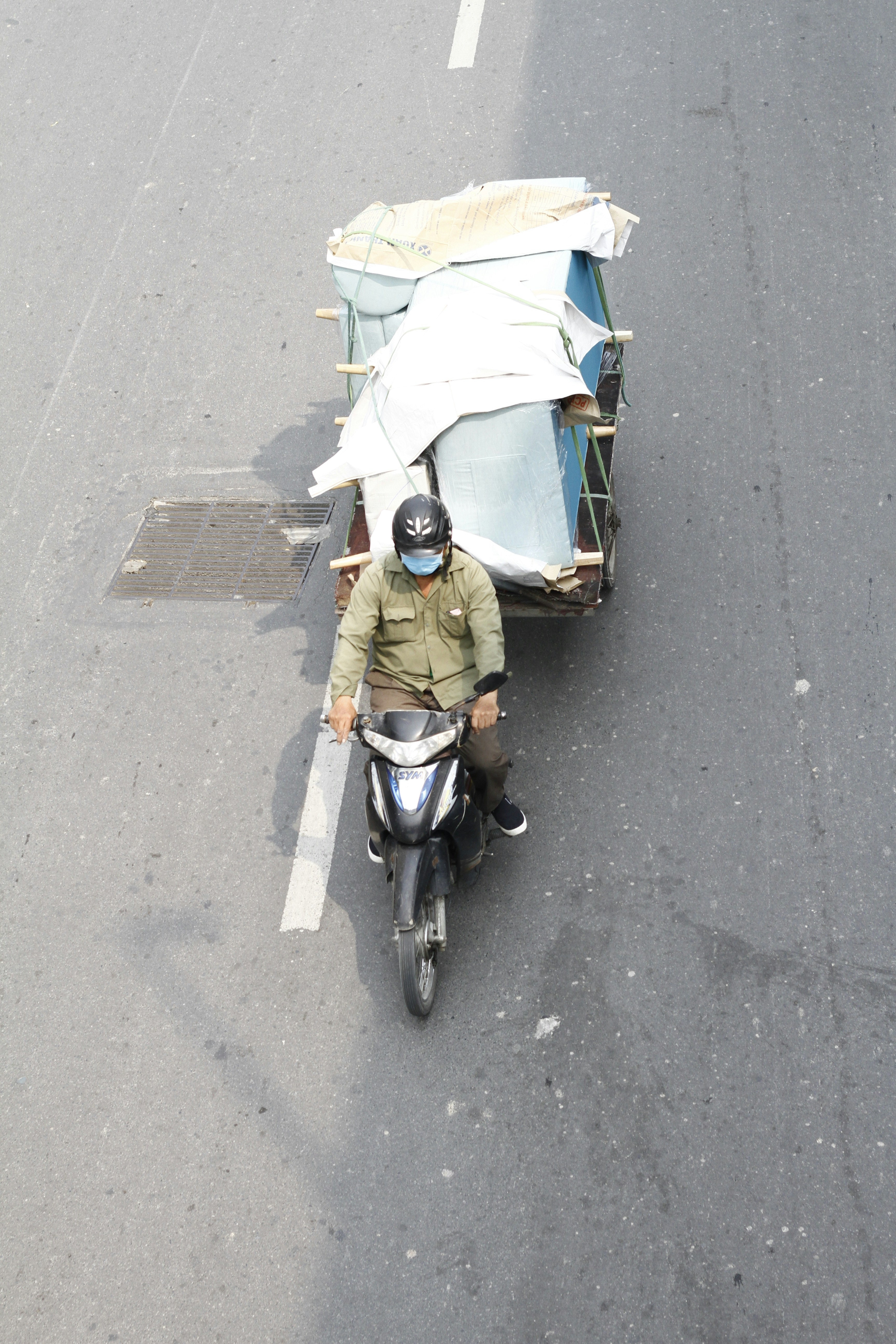 Man riding motorcycle with large cargo load