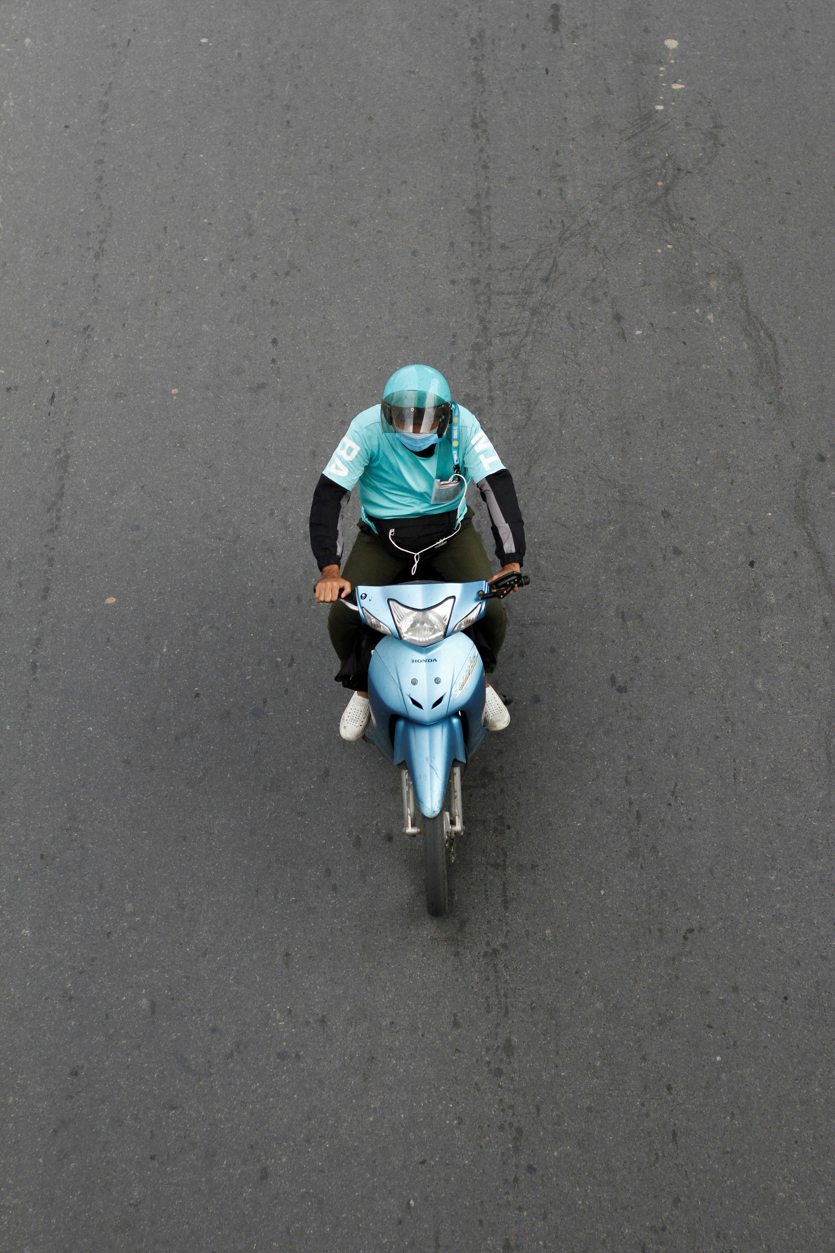 Aerial Rider: Top-Down View of a Turquoise-Clad Motorcyclist