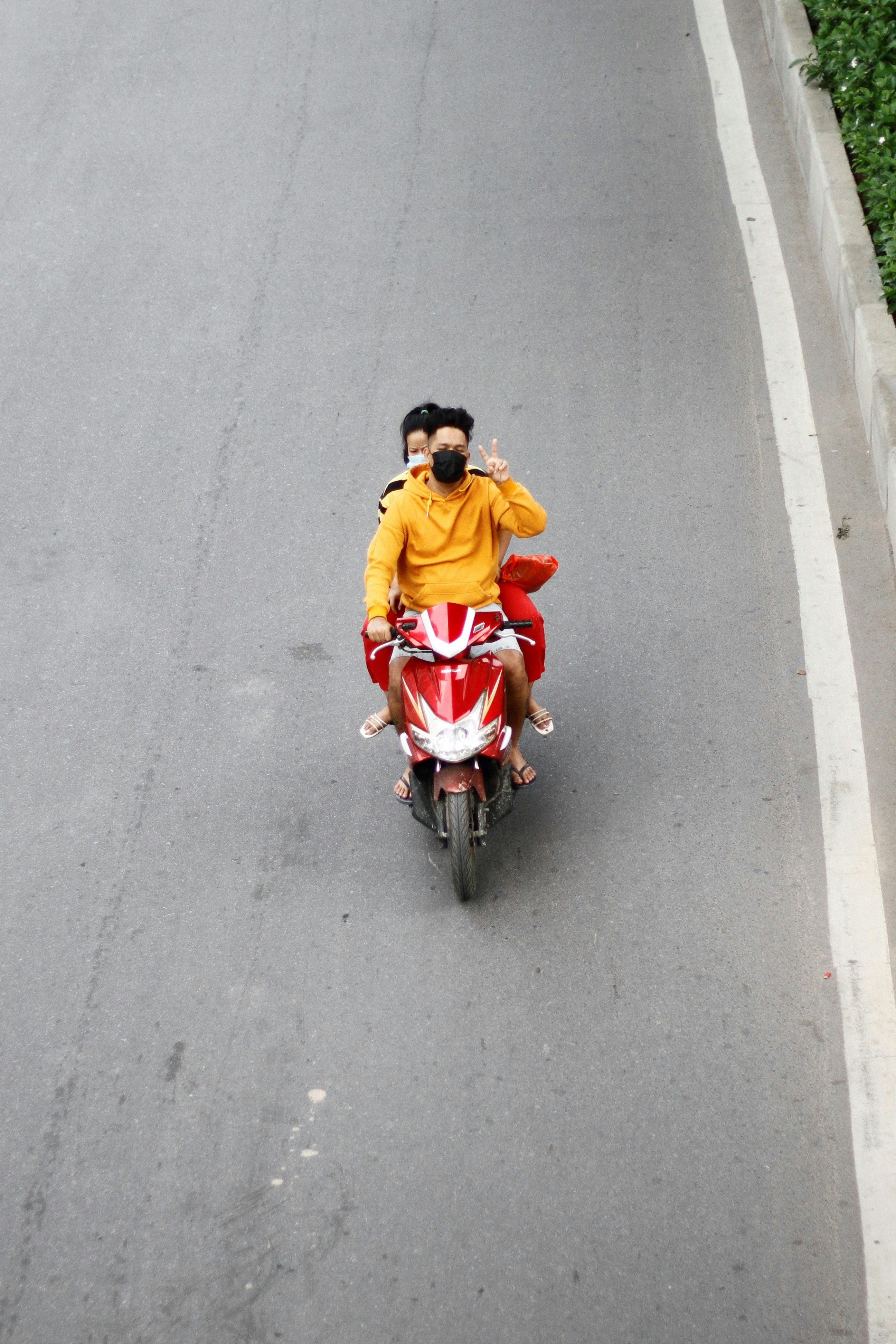 Motorbike in Hanoi, Vietnam | Person riding a red and white motorcycle on a road.