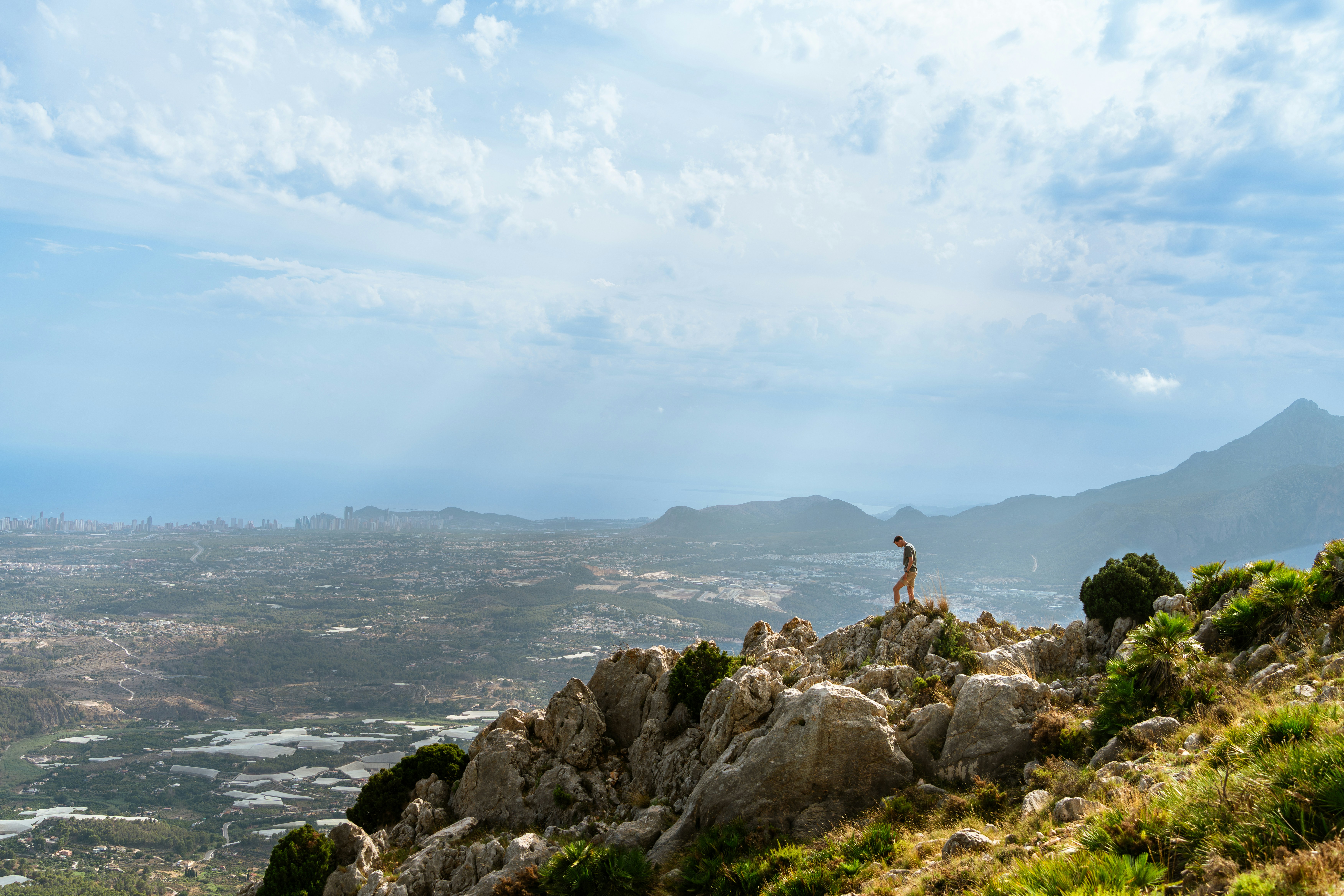 Lost in the view | Rocky mountain landscape with distant city under cloudy sky