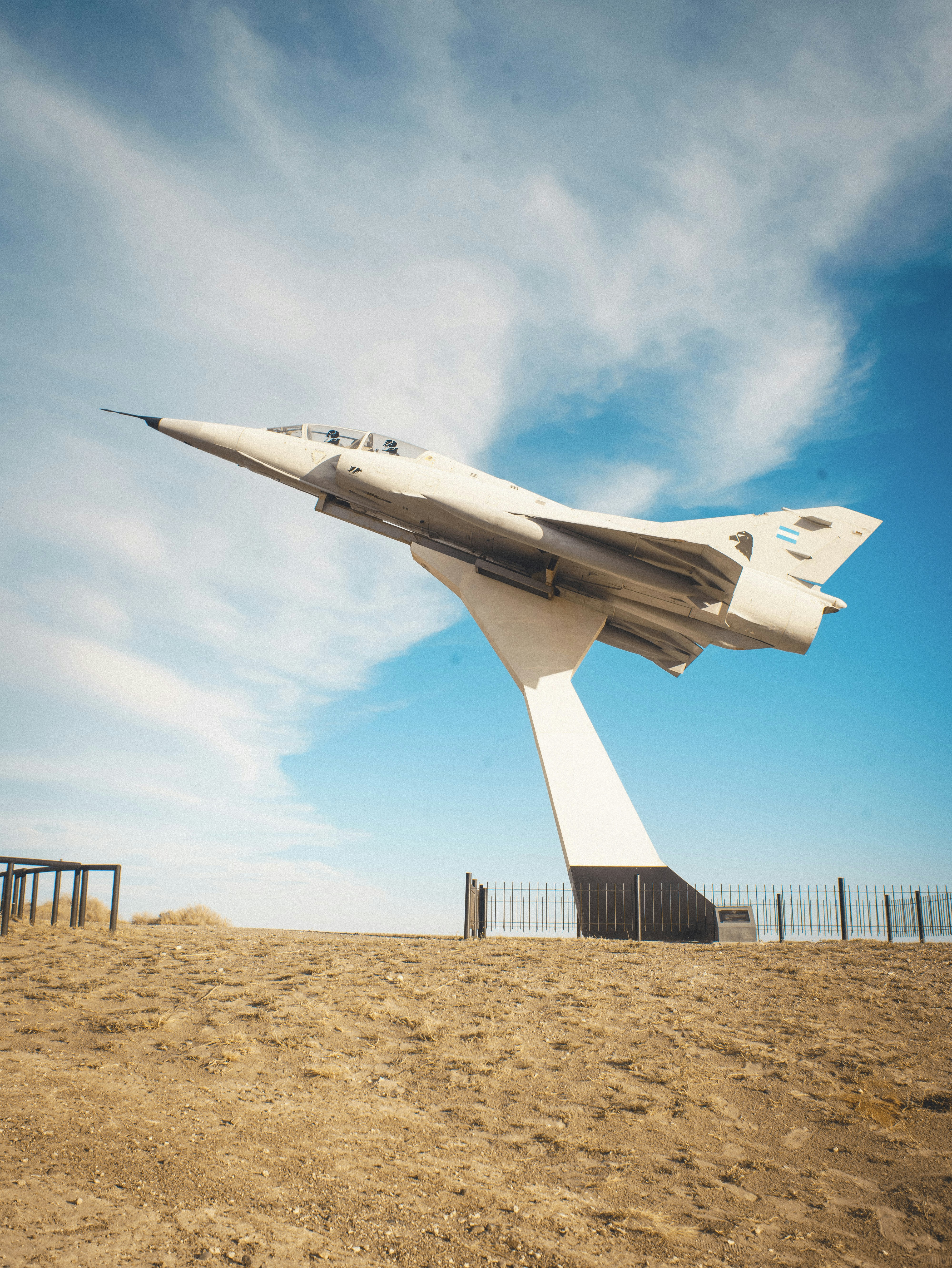 Fighter jet monument against a blue sky.
