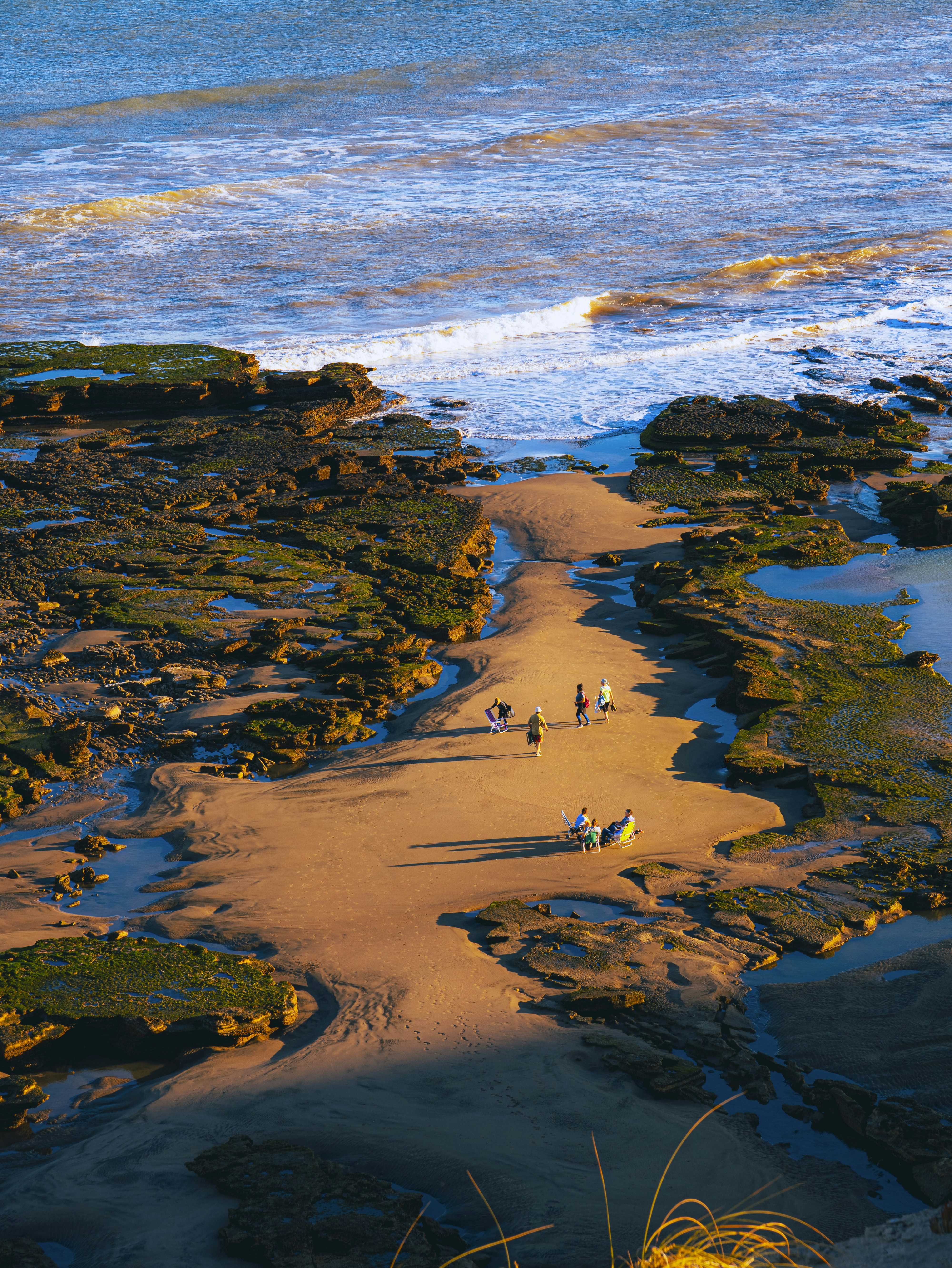 Rocky beach with waves crashing on shore at sunset