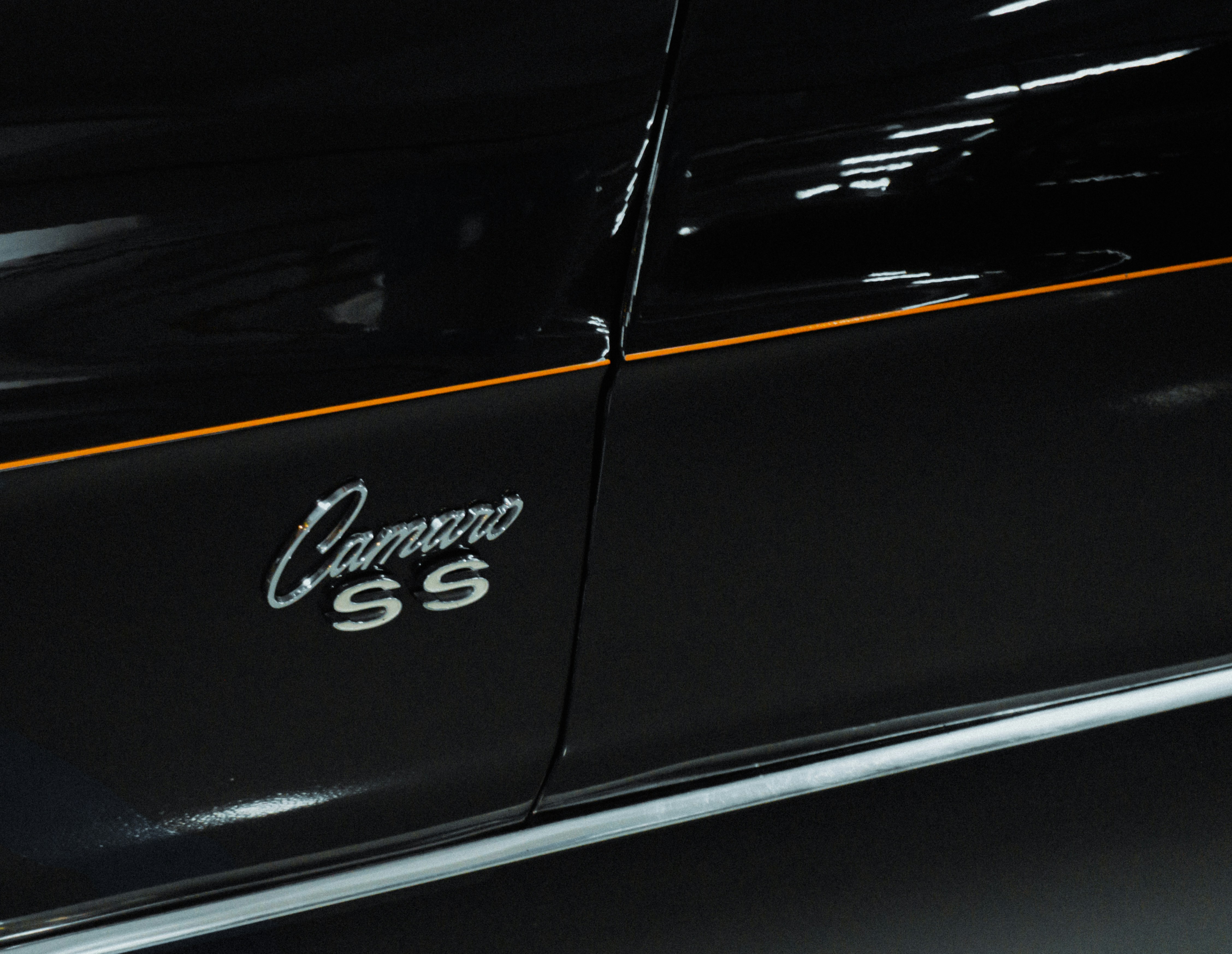 Carmine Script: Classic Emblem on a Black Vintage Car