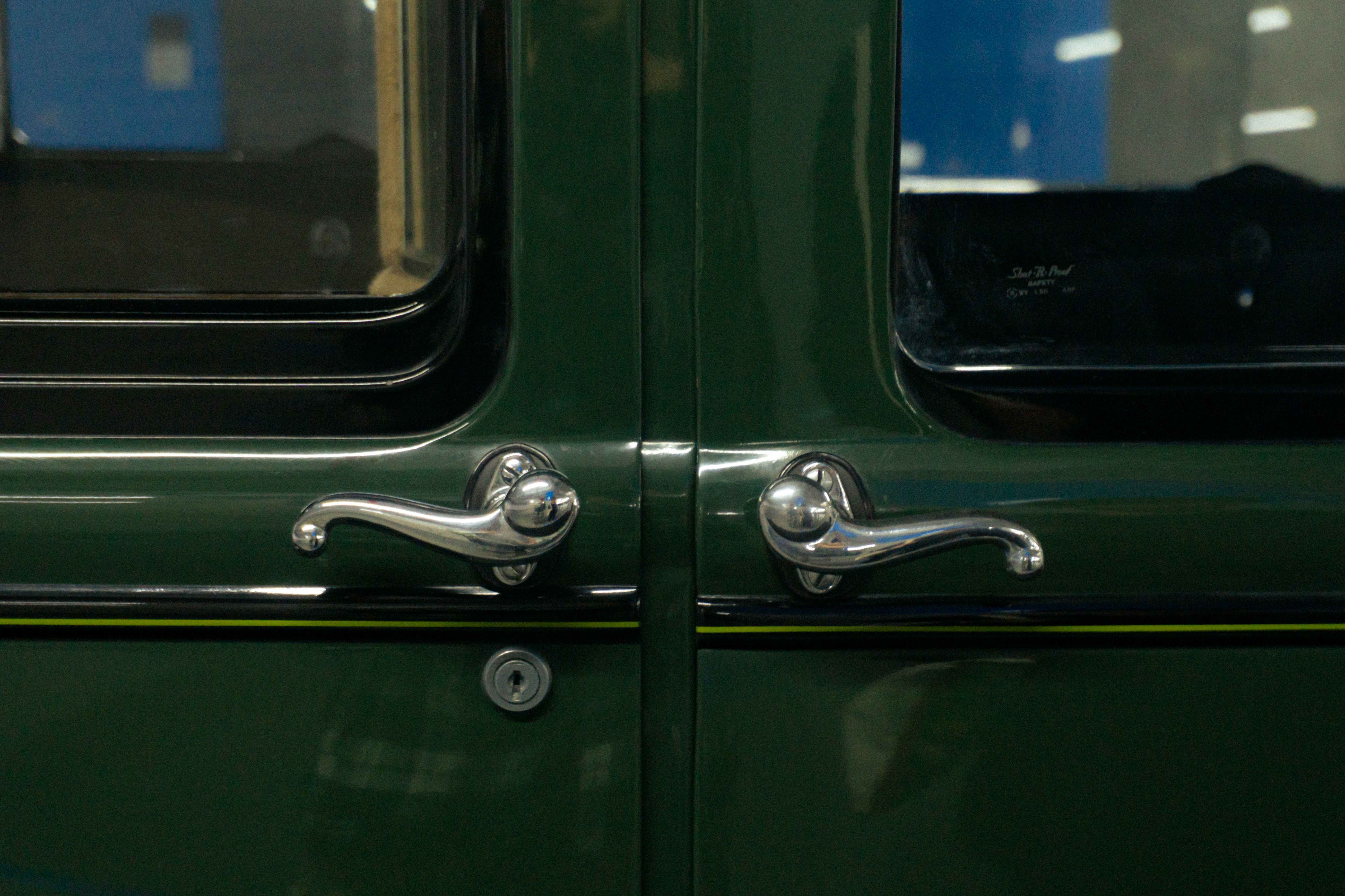 Close-up view of vintage car door handles and windows, showcasing intricate design and polished chrome details.