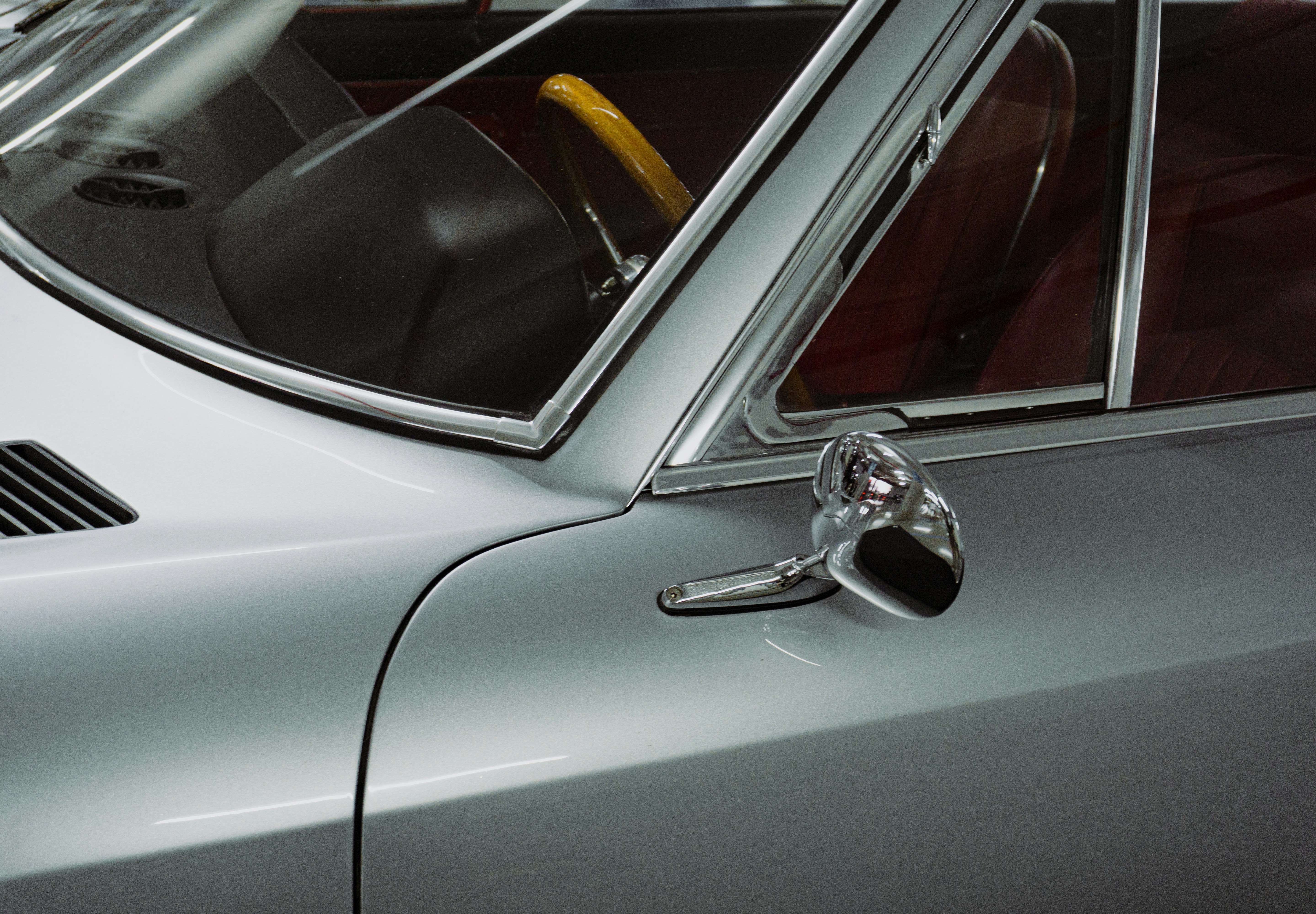 Close-up of a vintage silver car's side mirror.
