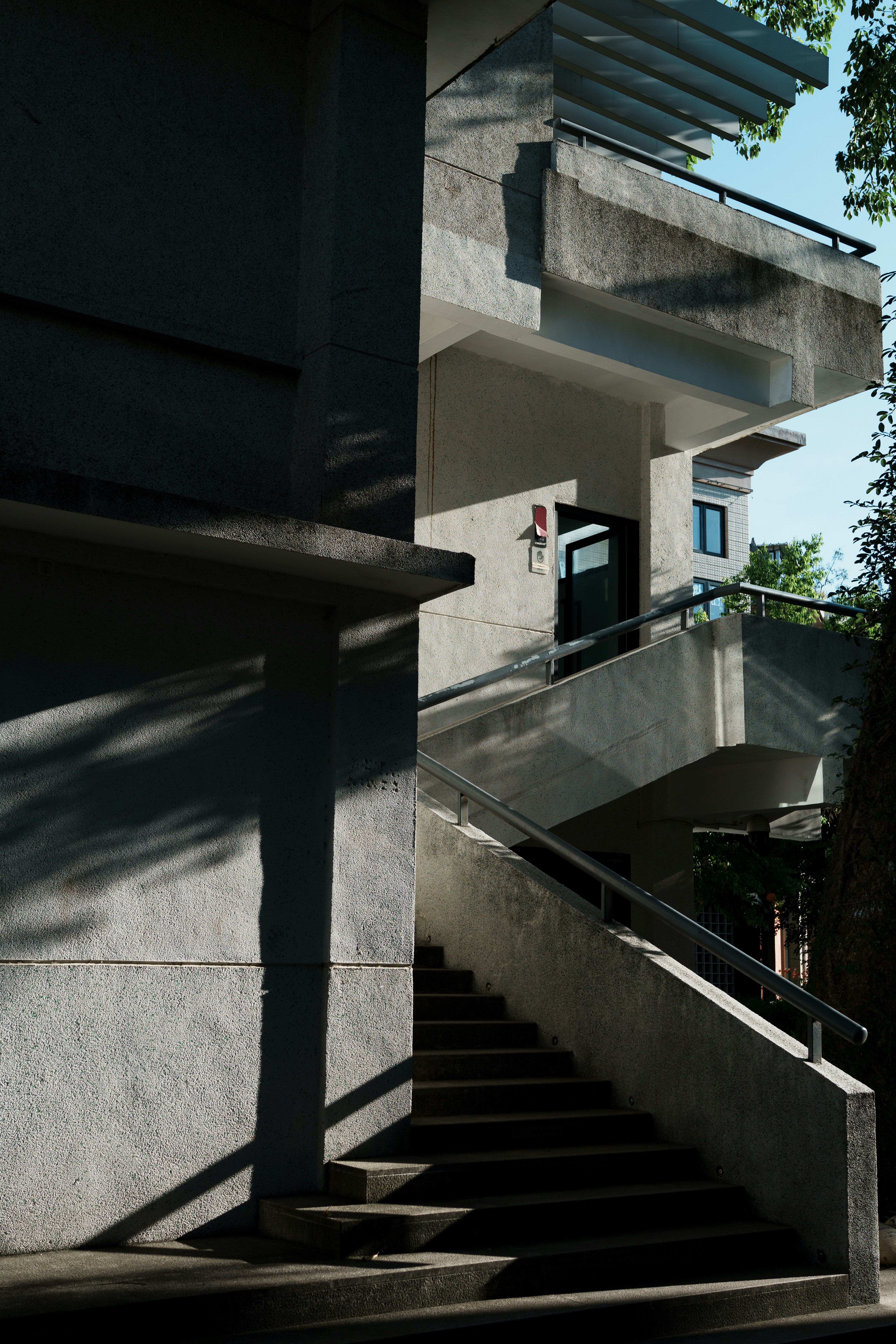 Concrete stairs ascend beside a building wall