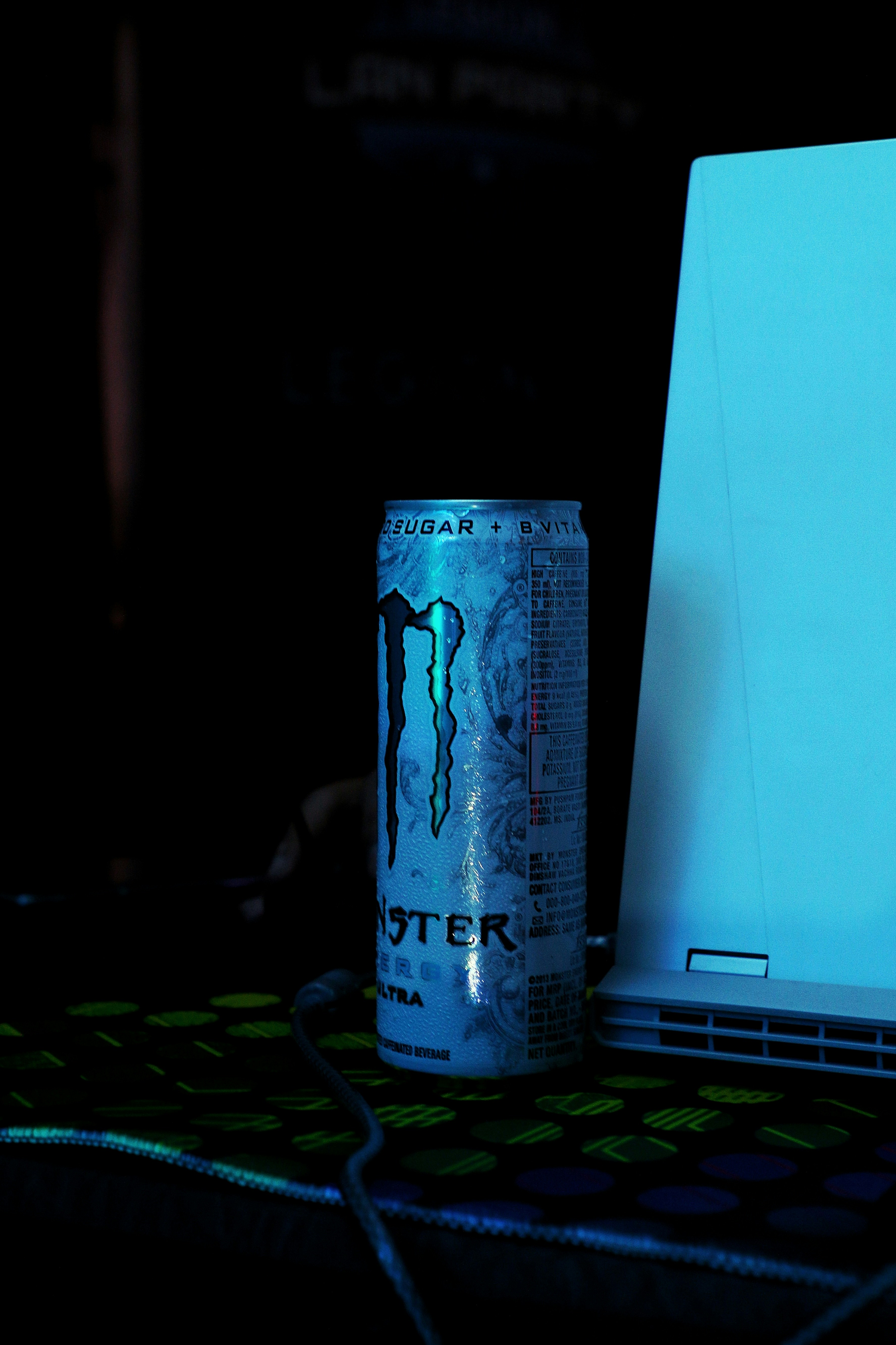 A can of monster energy zero sugar shown in a lighting setup of a gaming zone | Monster energy drink can next to white object