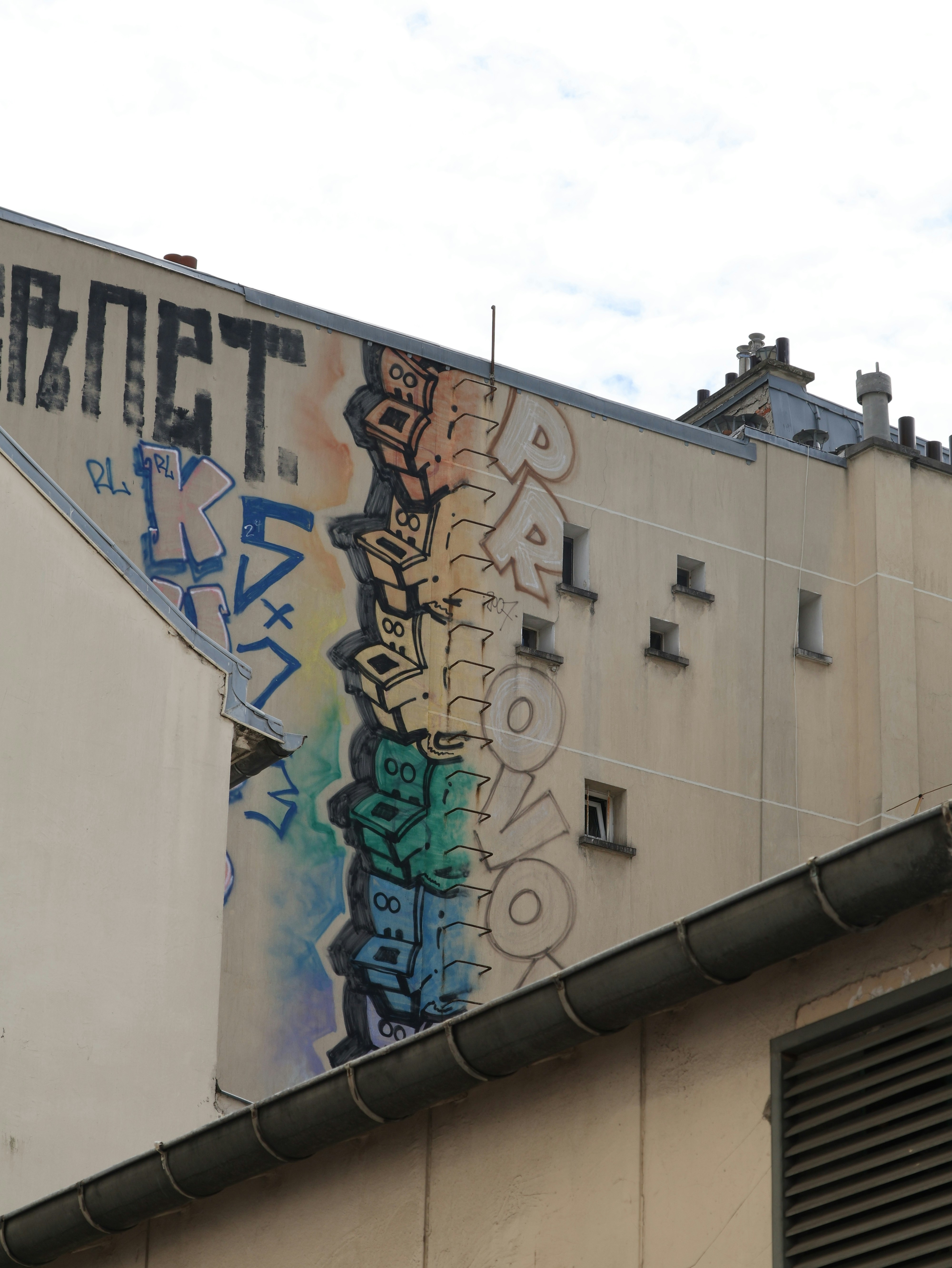 Vertical Graffiti Tower: A Rainbow Stack Climbing the City Wall
