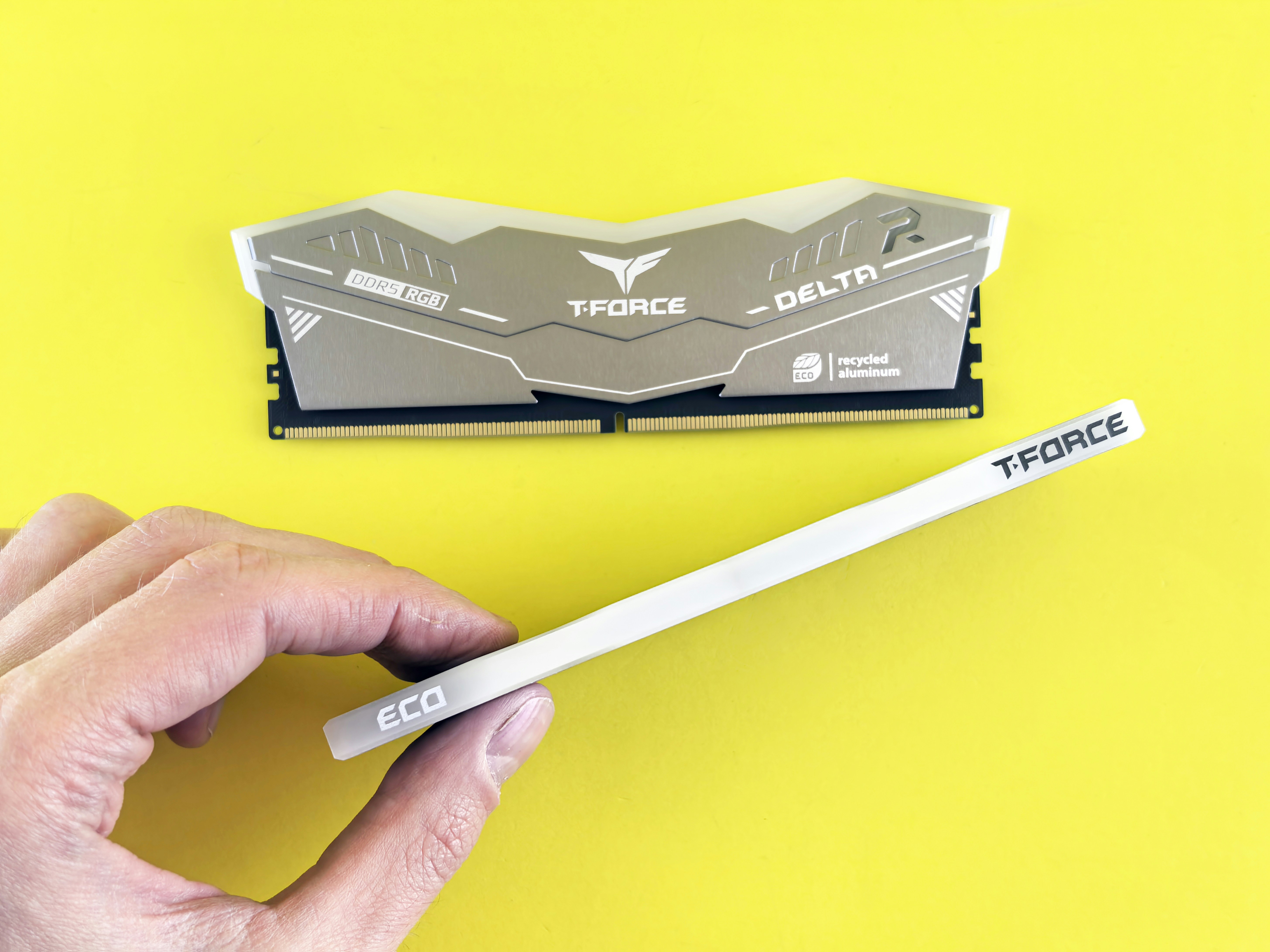 Hand holding ram stick with computer component above.