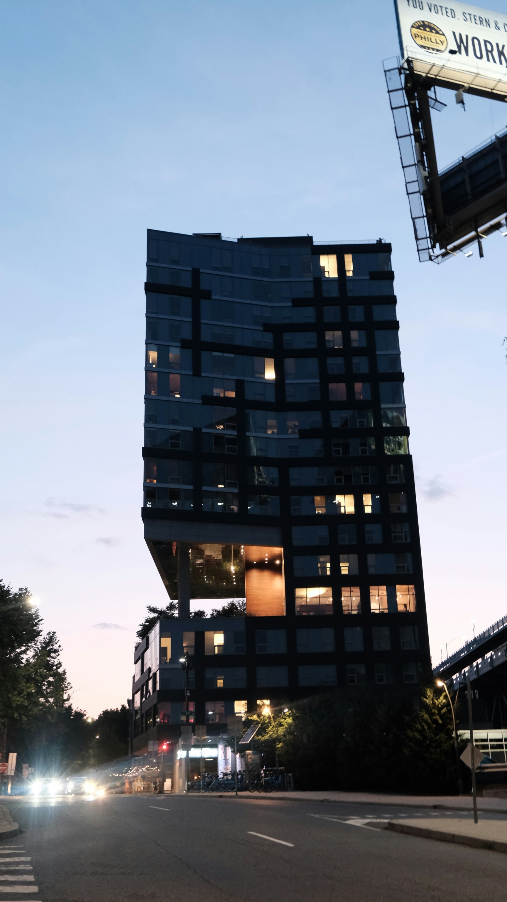 Modern dark building with illuminated windows at dusk