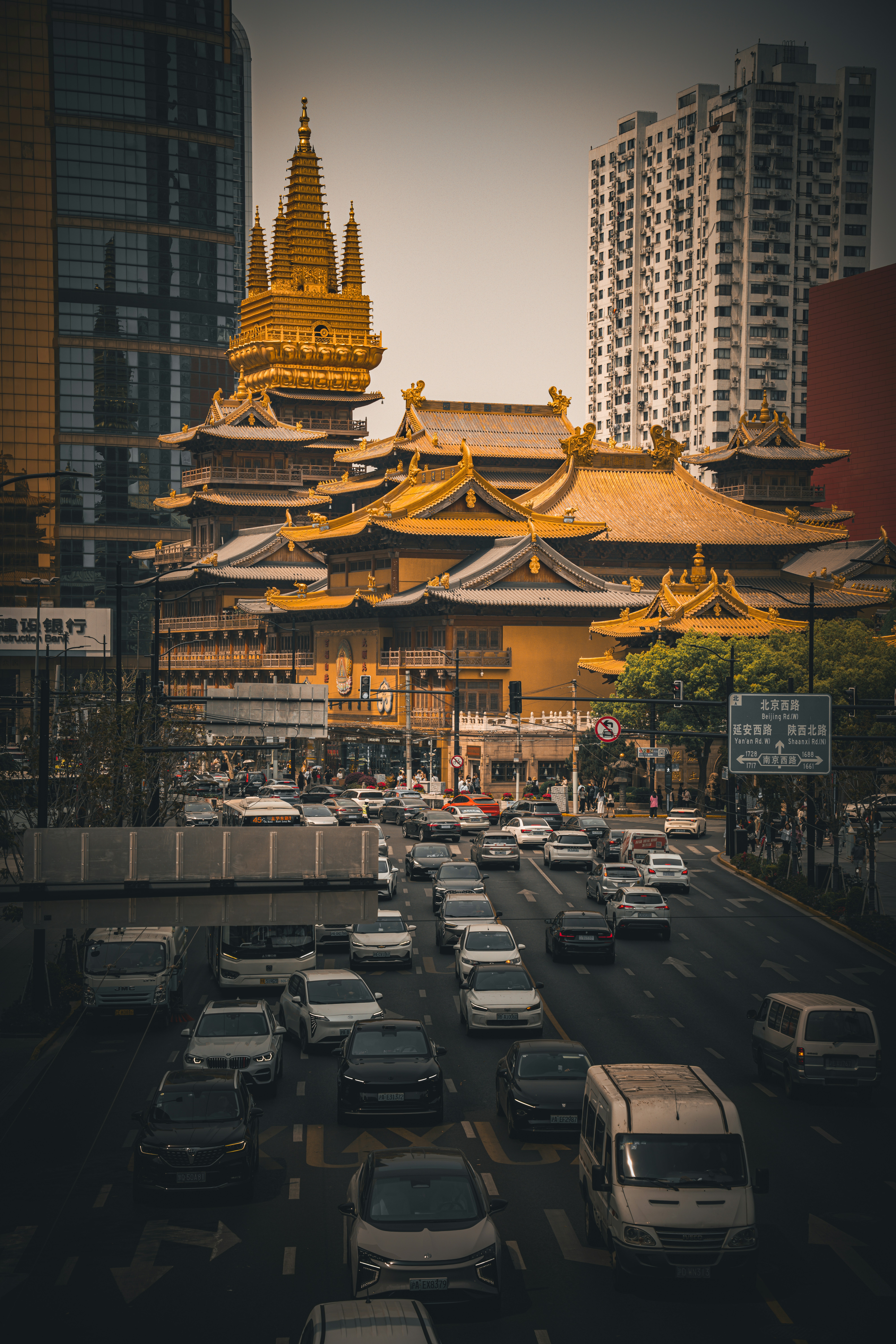 Golden temple structure amidst busy city traffic
