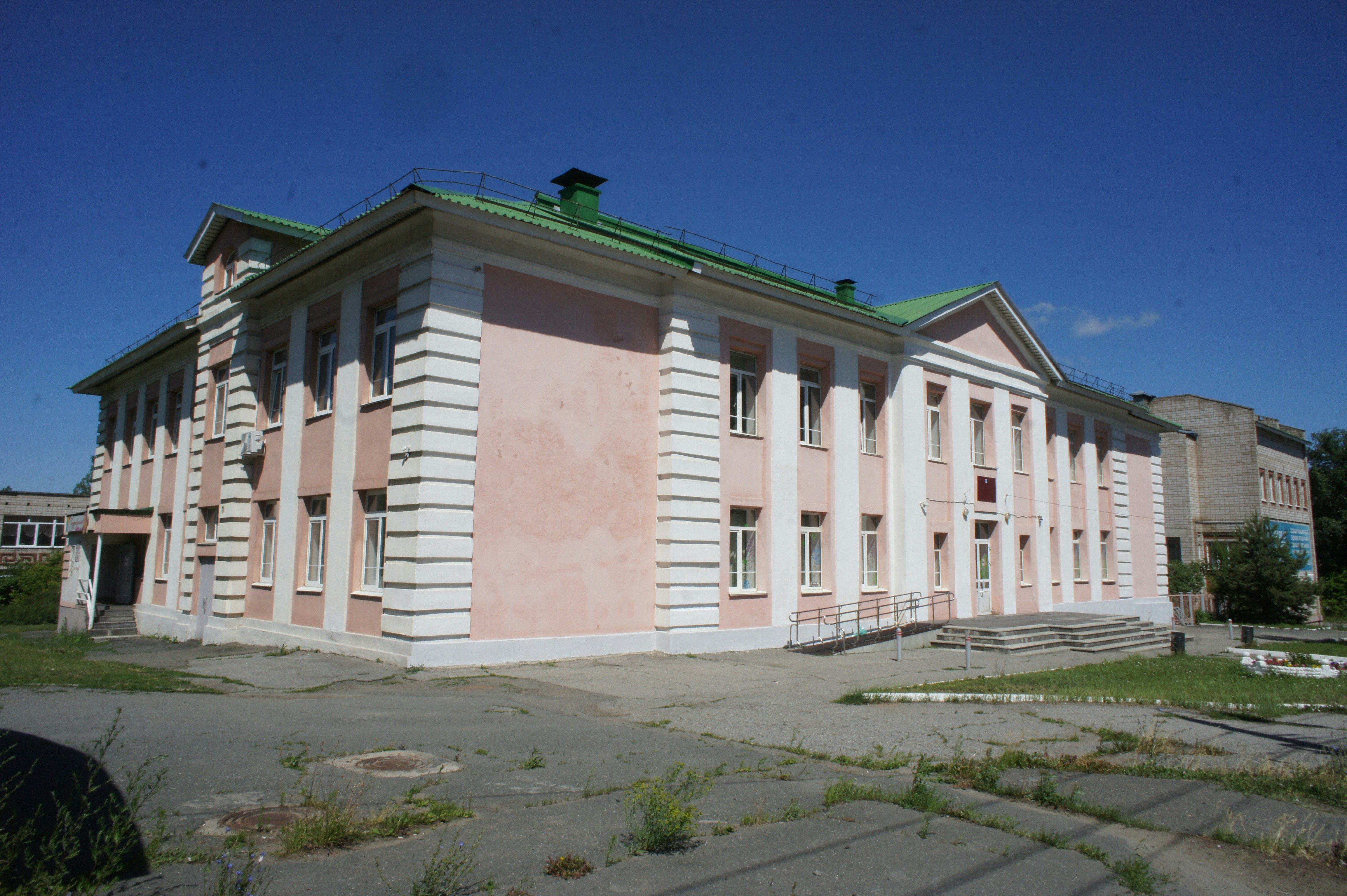 Large building with a green roof under blue sky