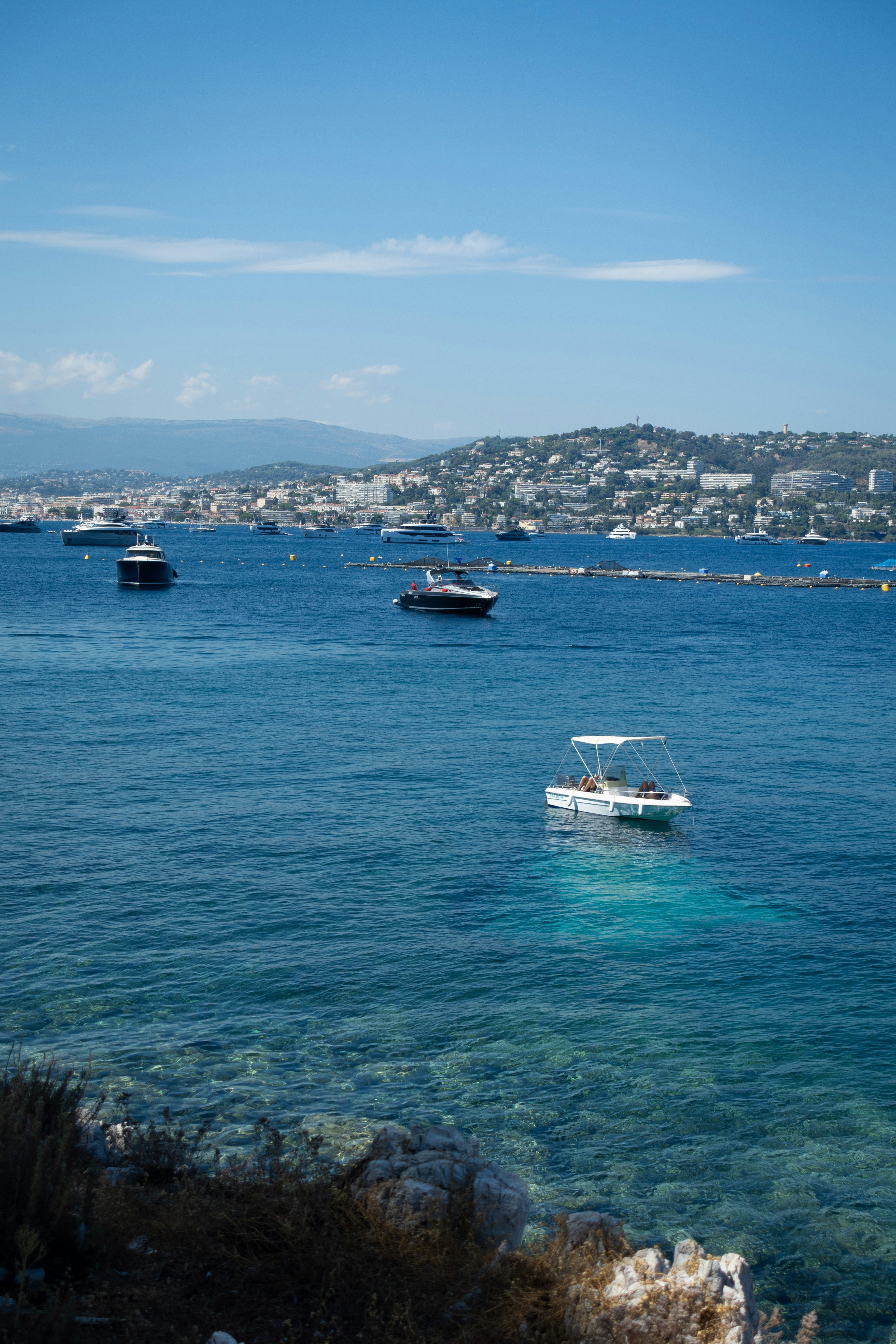 Boats on the blue ocean near a coastal town