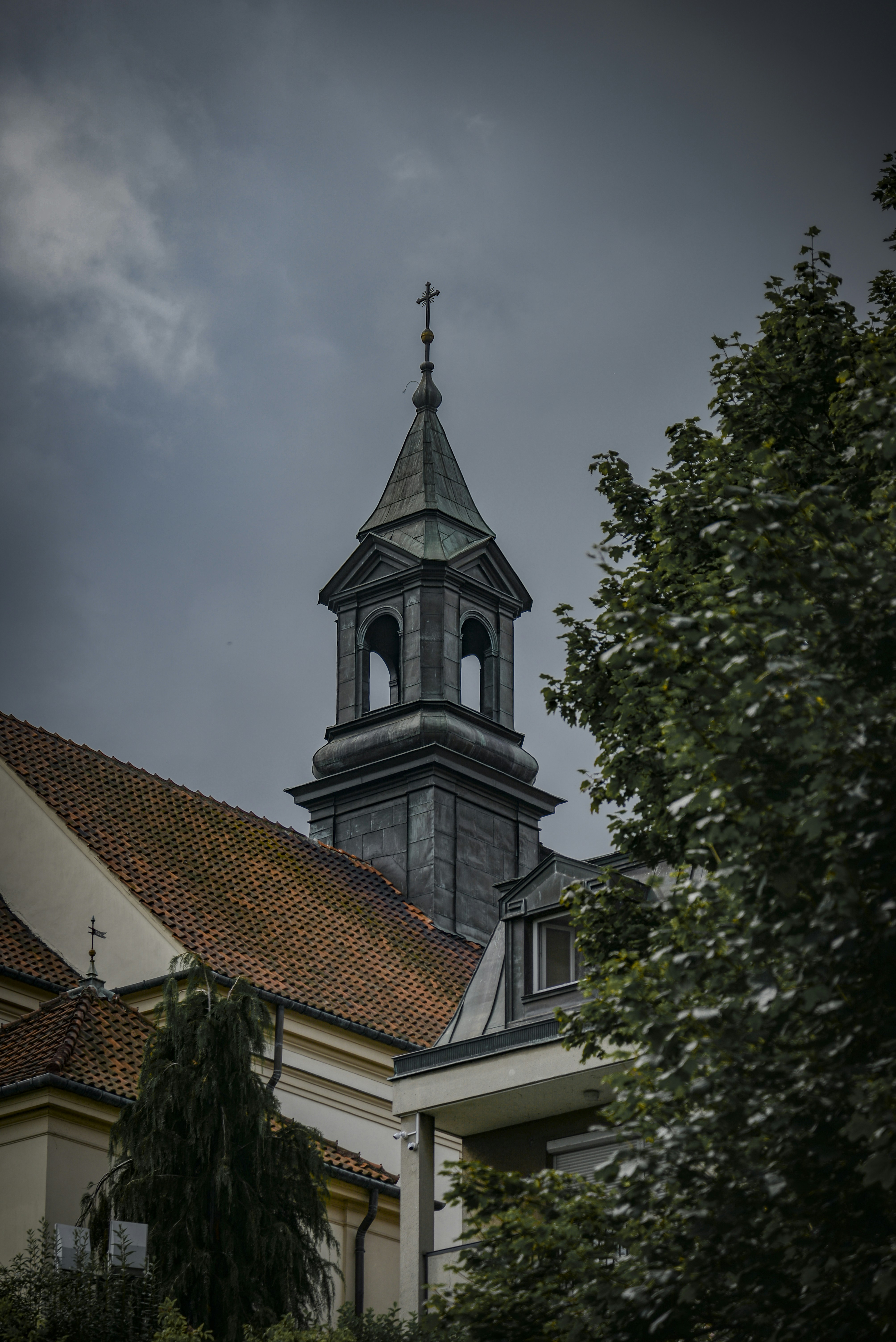 Church tower and roof against cloudy sky